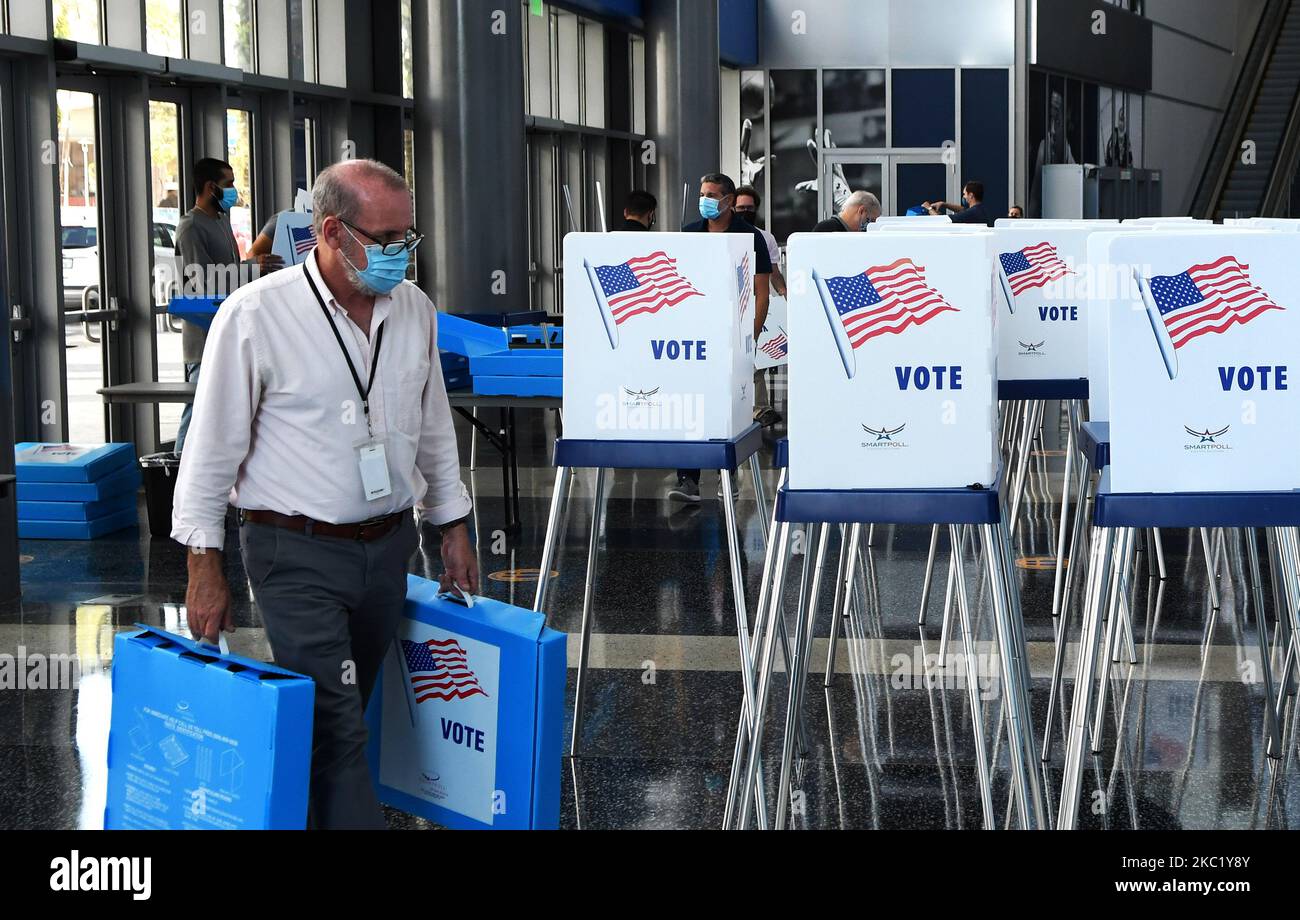 Election workers set up voting booths at an early voting site ...