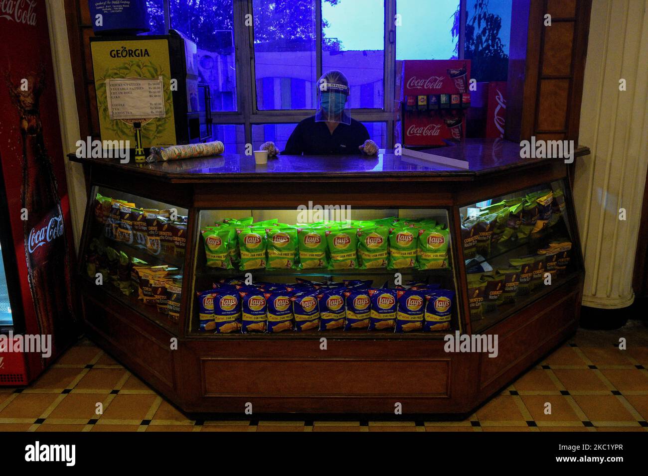 A cinema hall staff wearing protective gear inside a beverage stall at ...
