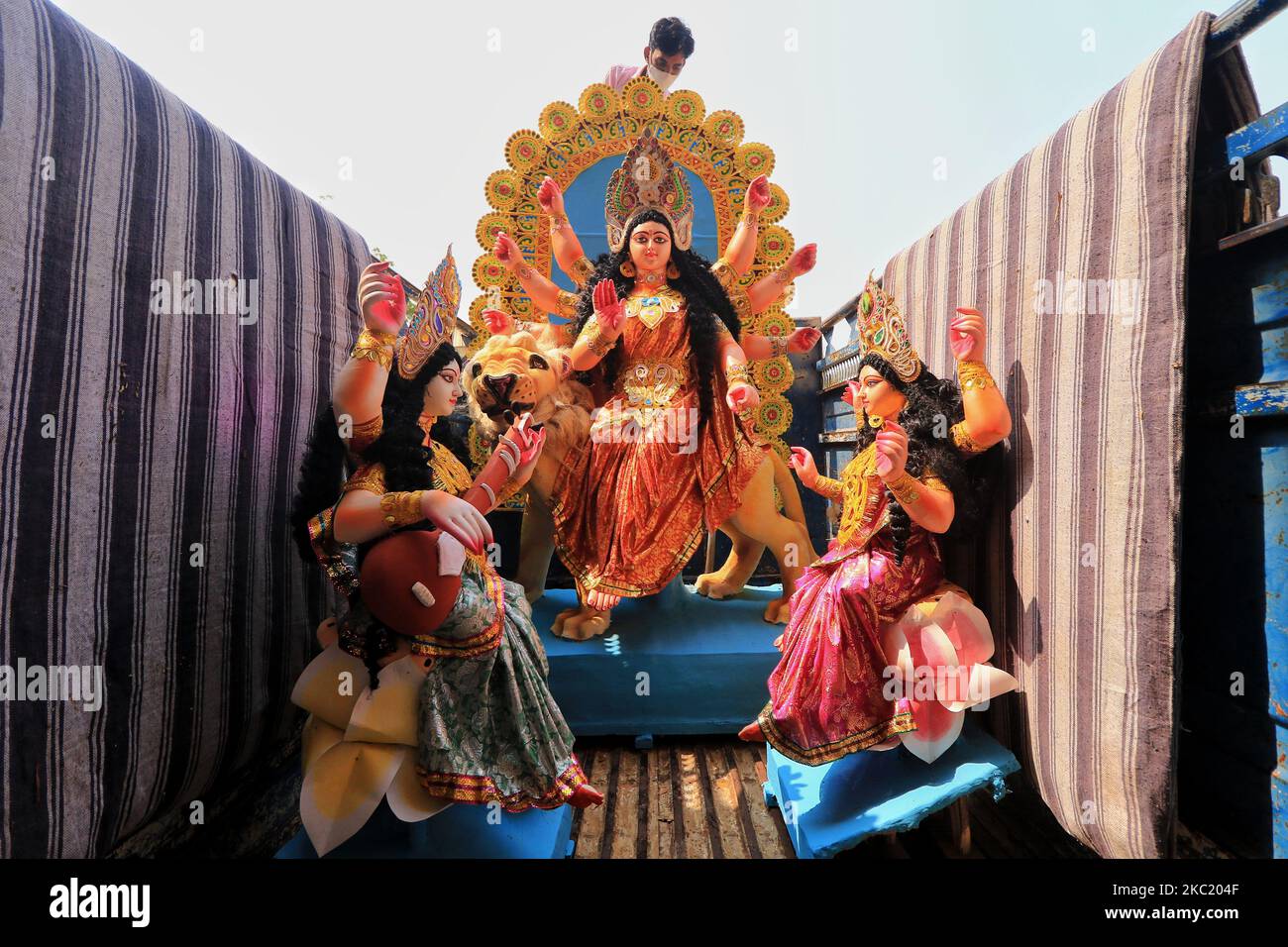 Jaipur: Devotees carry an idol of Goddess Durga as they load in pickup ...