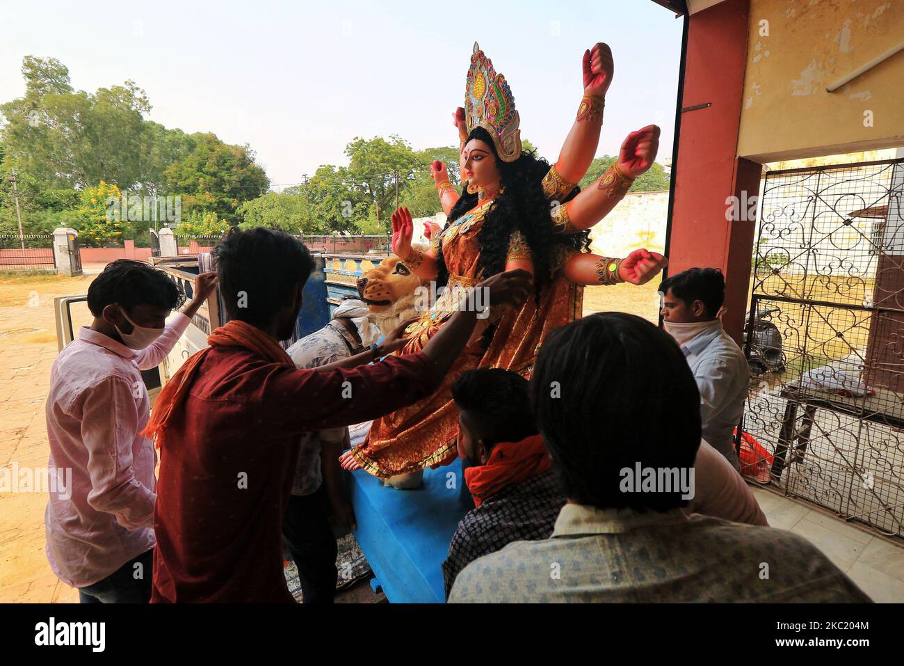 Jaipur: Devotees carry an idol of Goddess Durga as they load in pickup ...
