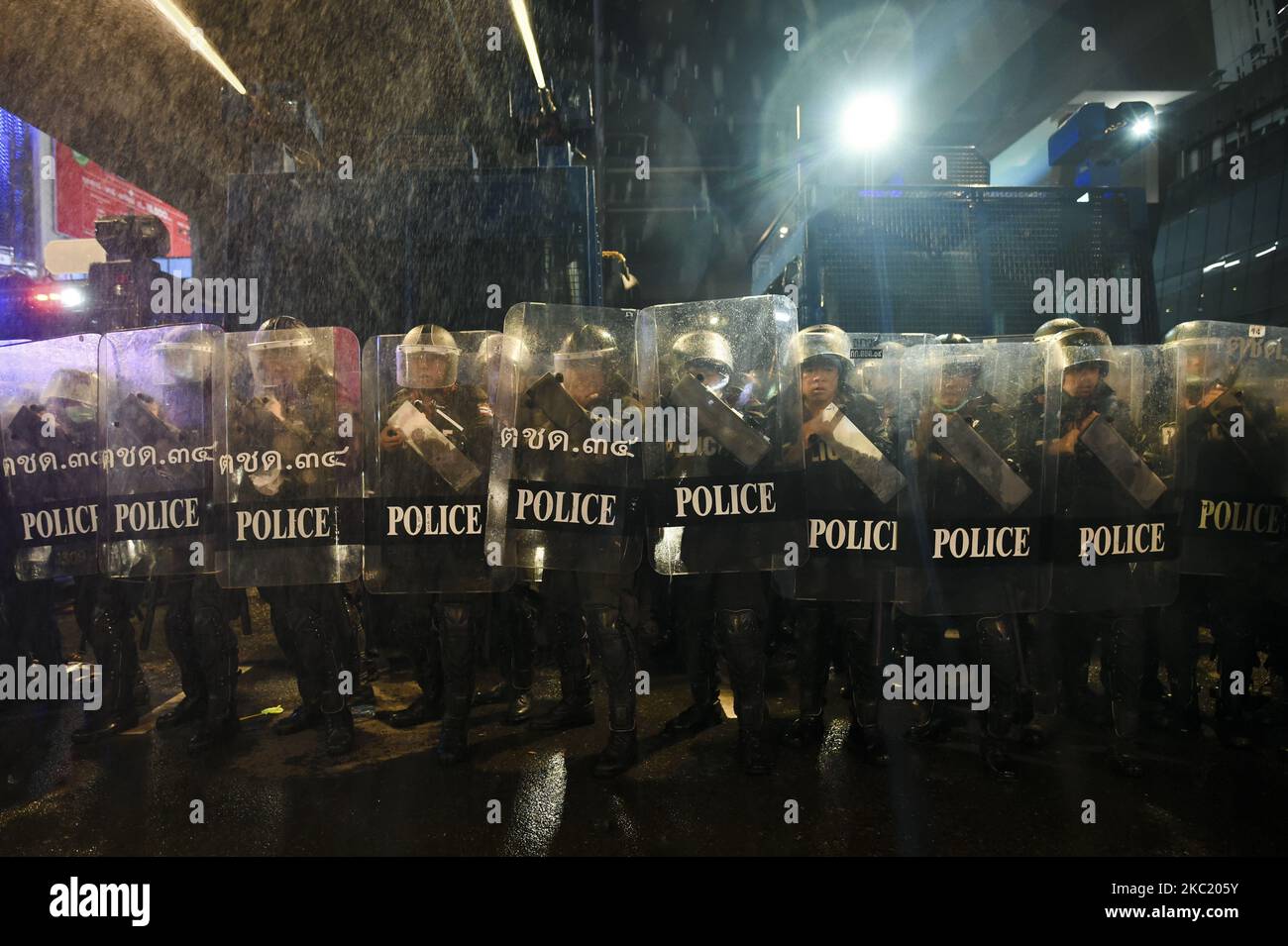 Thai riot police stand in line behind their shields during an anti ...