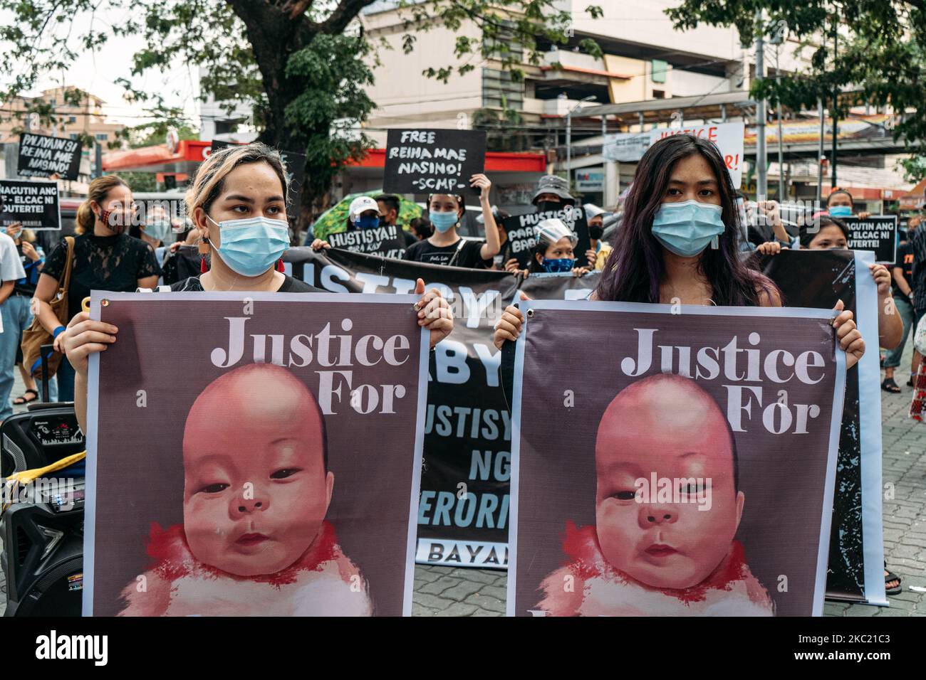 Protesters hold placards calling for justice outside the Manila North ...