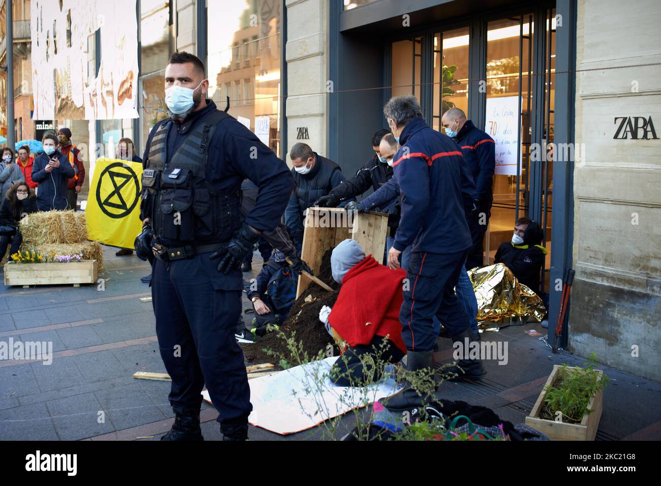 Policemen extract activists chained to the Zara's shop entrance doors ...