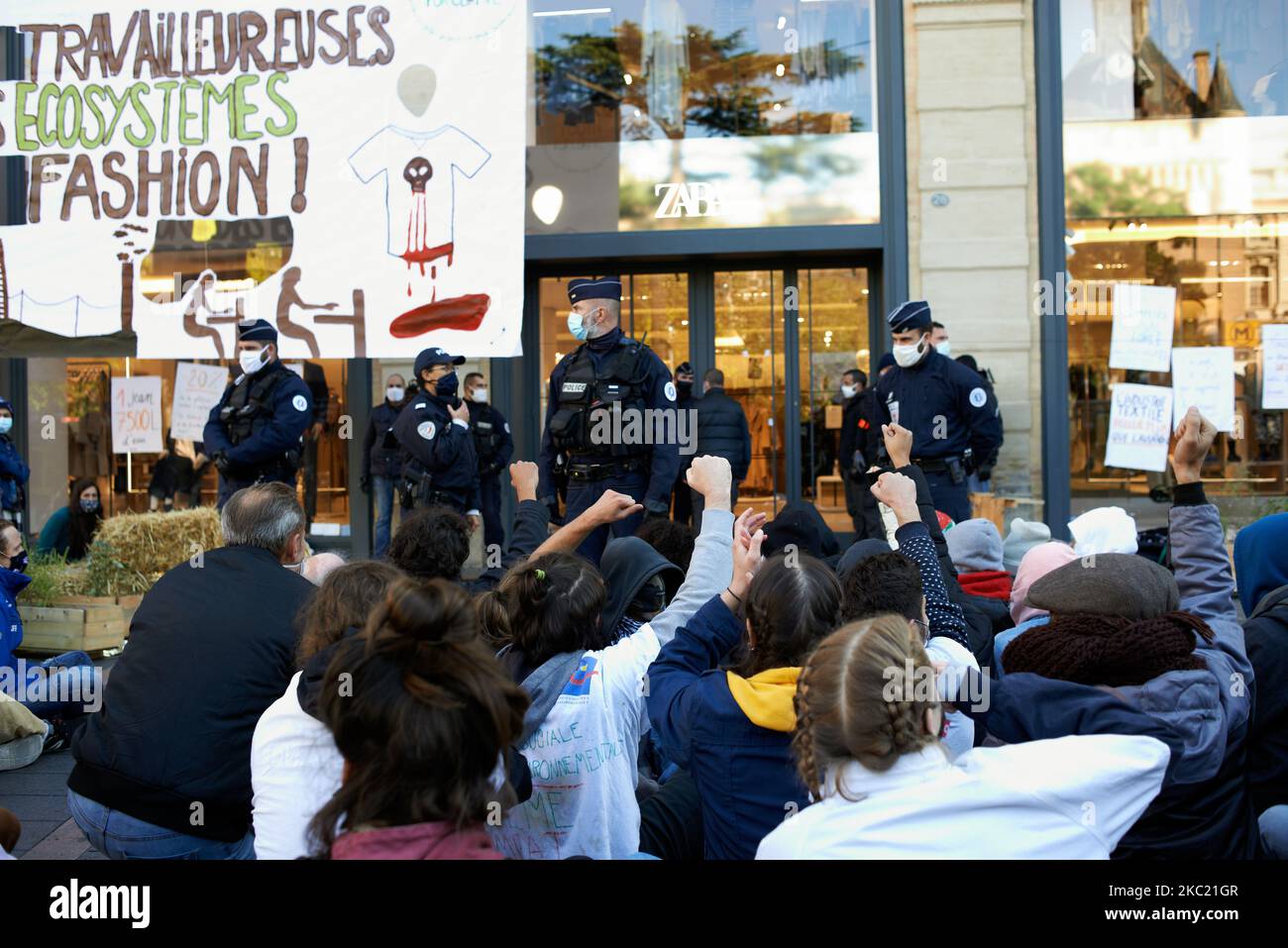 Policemen stand guard in front of the Zara shop in front of activists ...