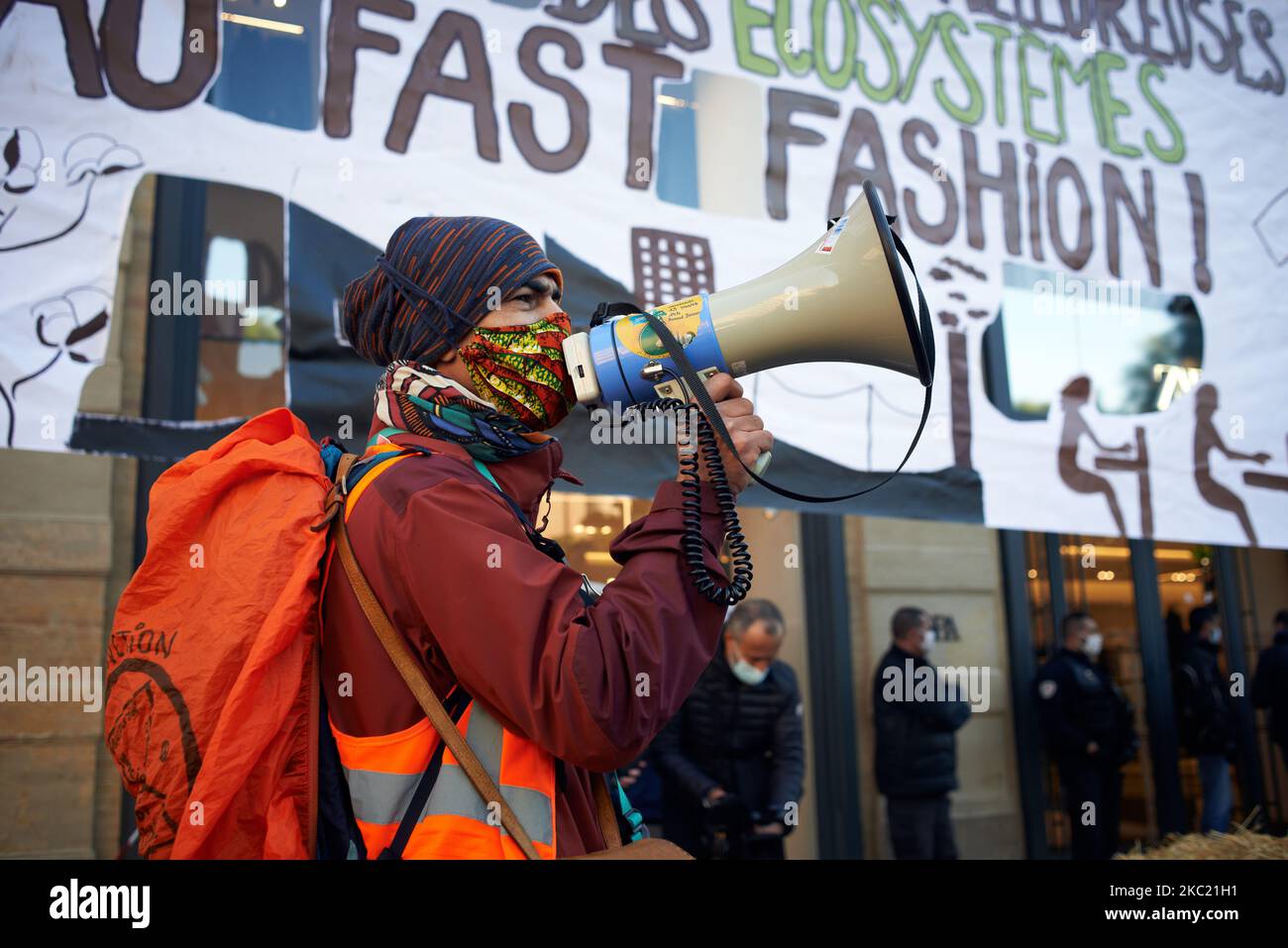 An activist makes a sppech in front of a giant banner reading 'Stop to ...