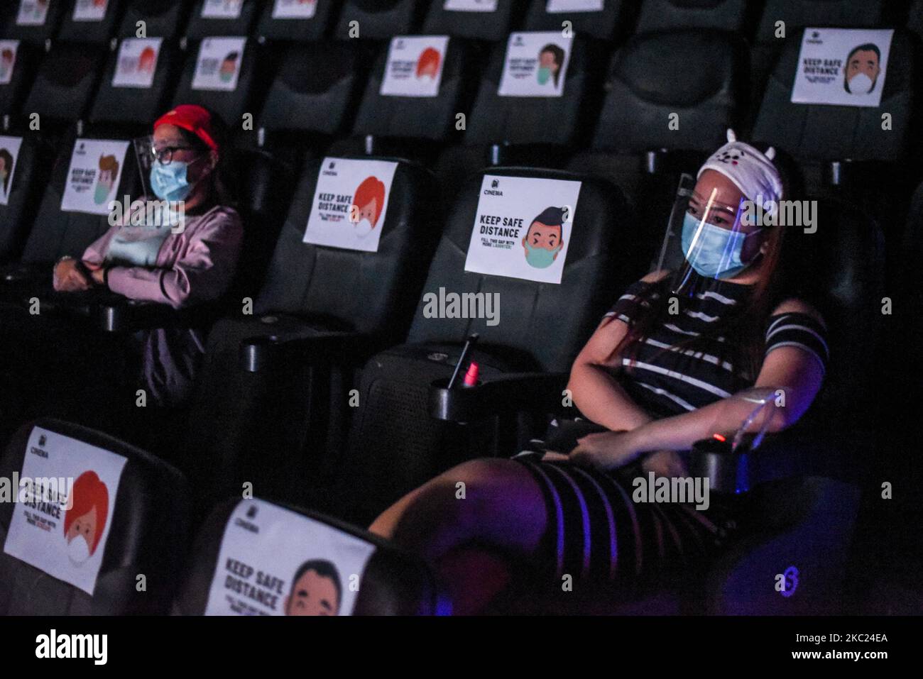 People wearing face masks and face shields observe social distancing as ...