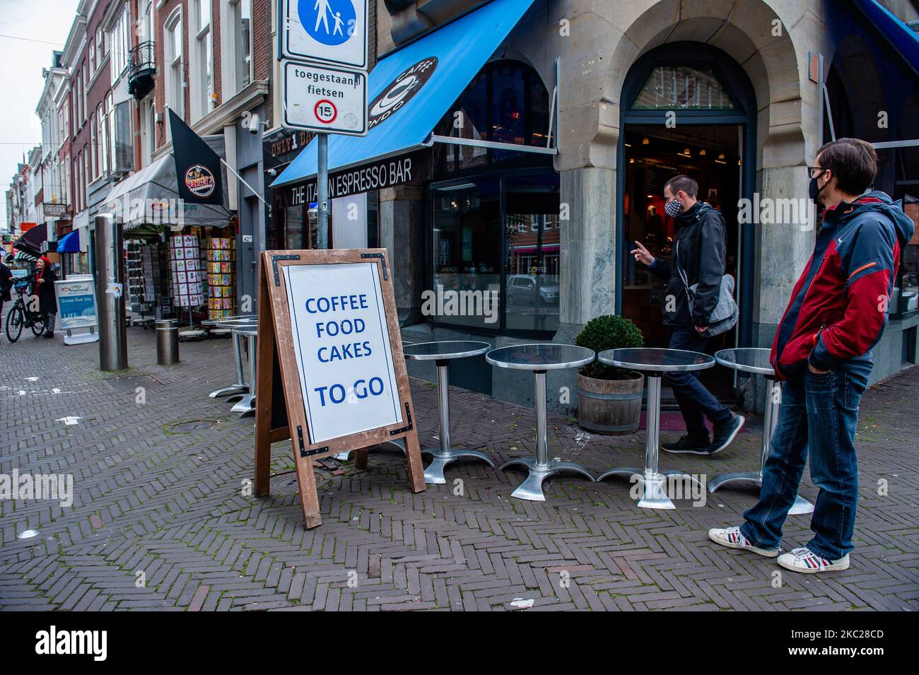 People are waiting outside of a cafeteria to pick up drinks to go ...