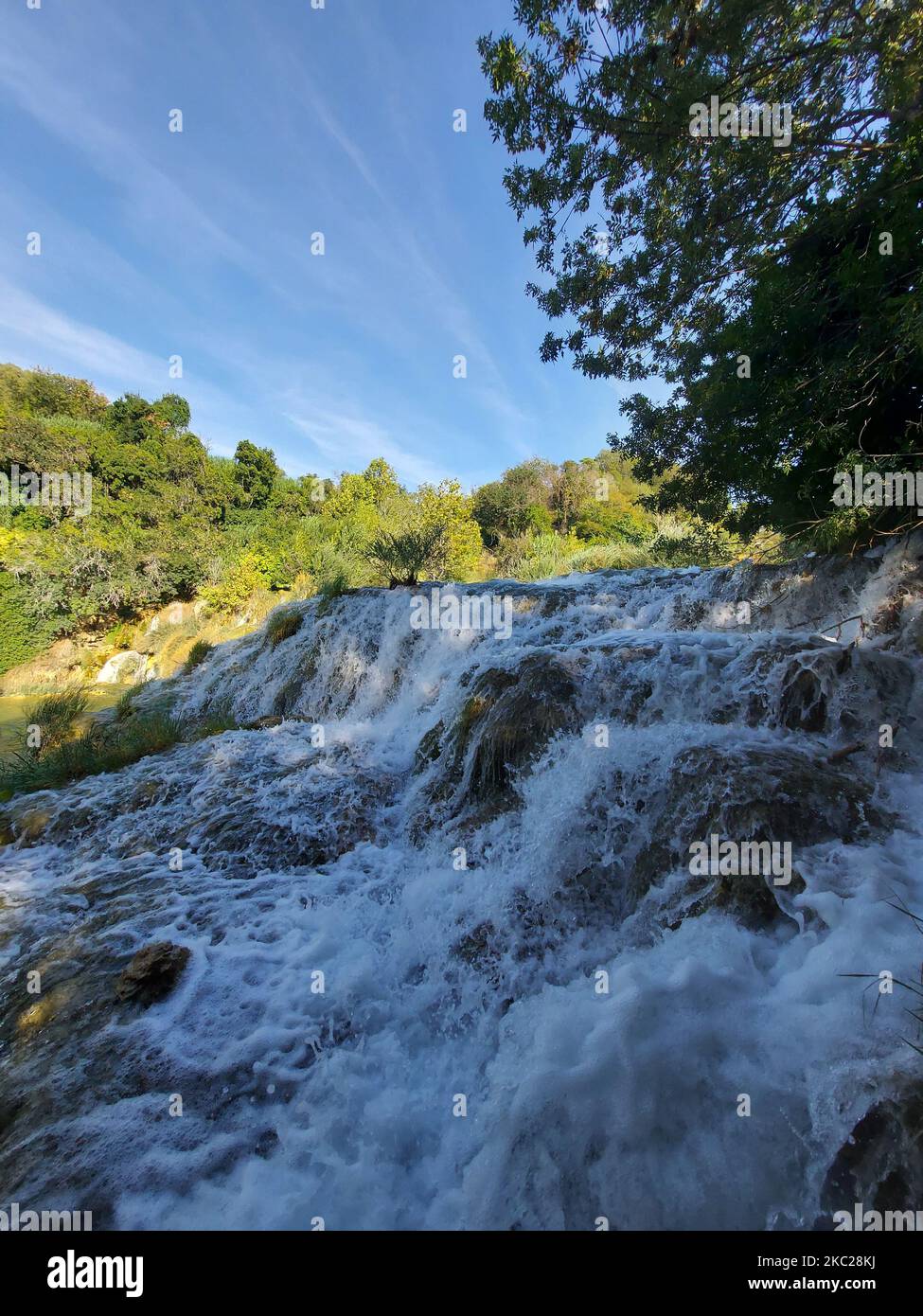 A river flowing through the rocks surrounded by the forests under the ...