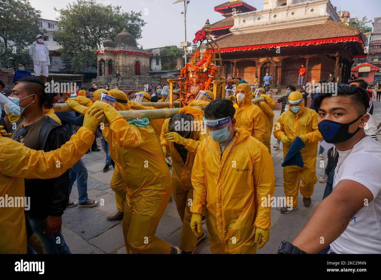 Hindu devotees wearing protective gear carry an idol of deity Pachali ...