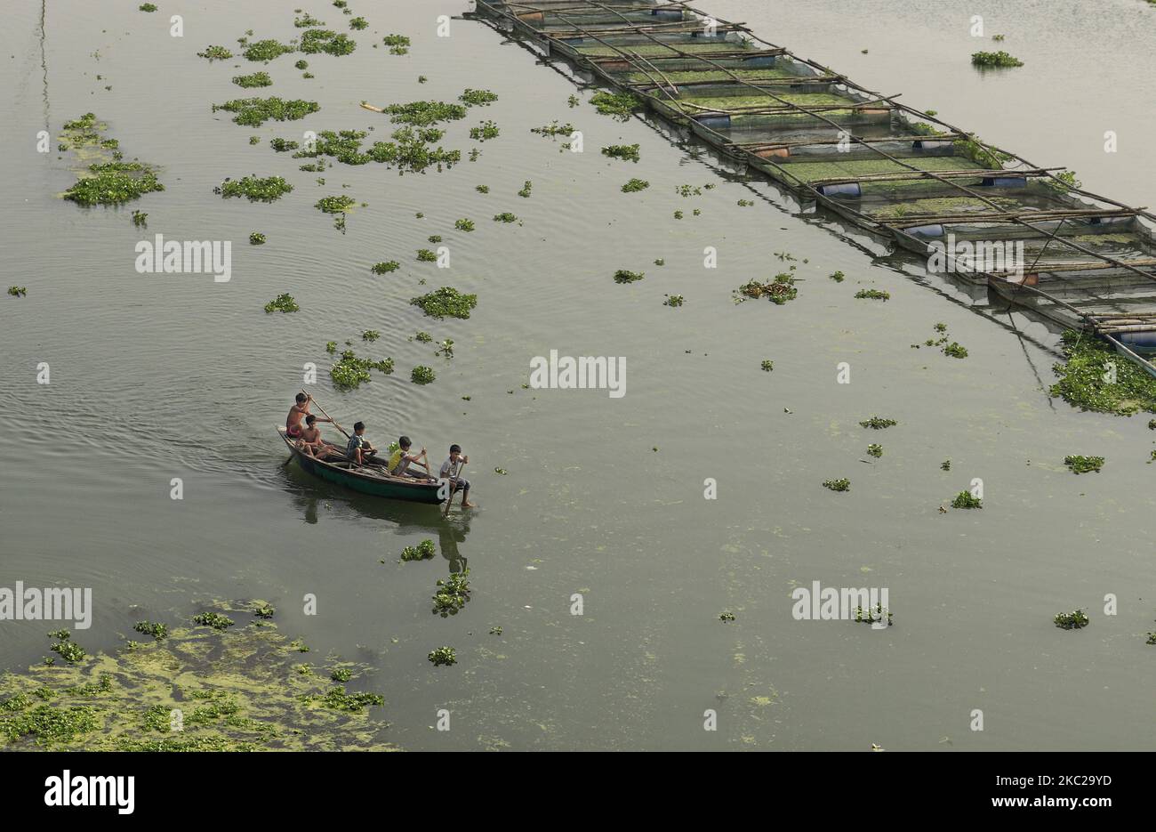 An aerial view of children riding a boat in a green pond in Sirajganj, Bangladesh Stock Photo ...
