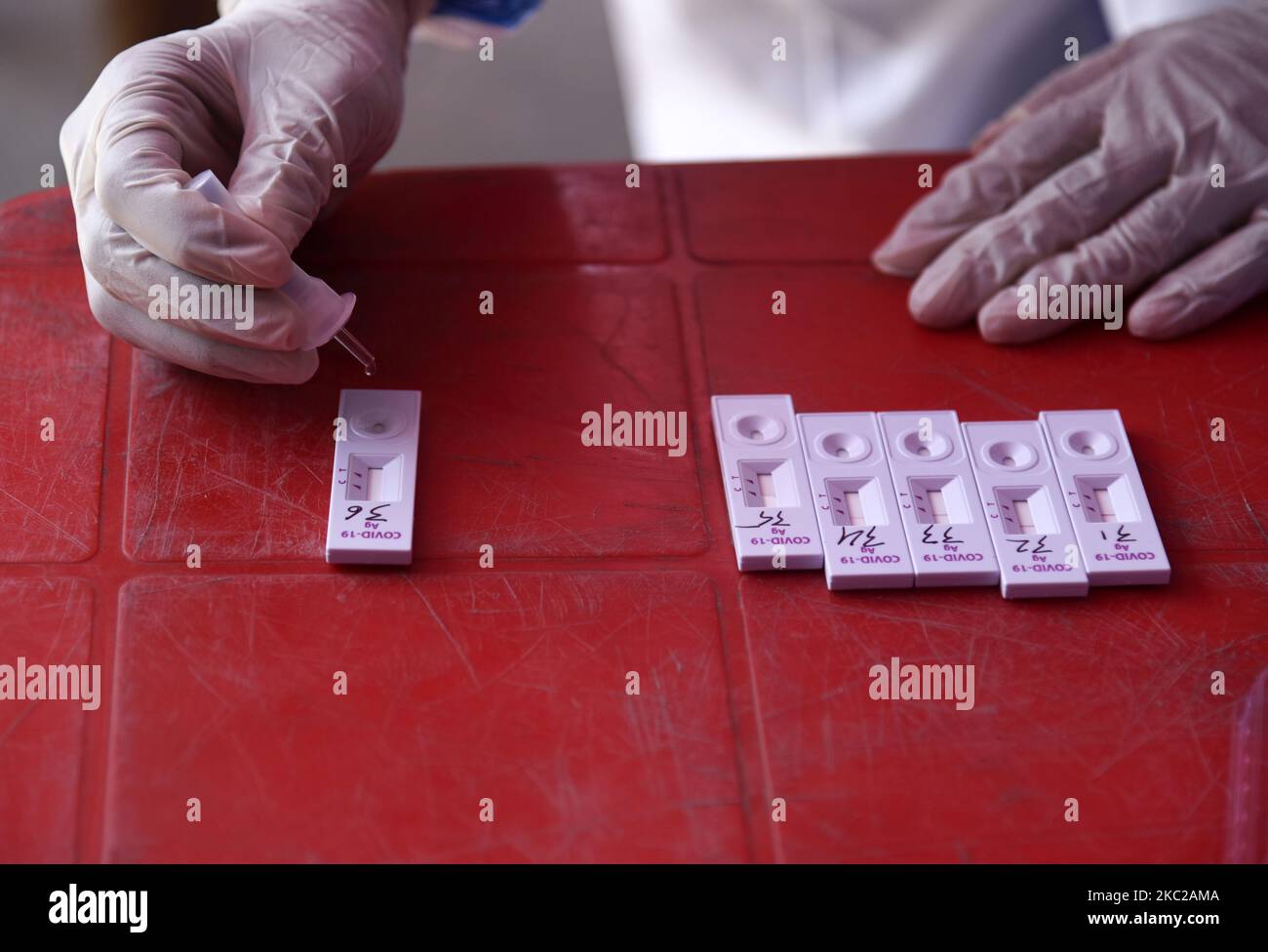 Health worker in personal protective equipment (PPE) collects a nasal ...