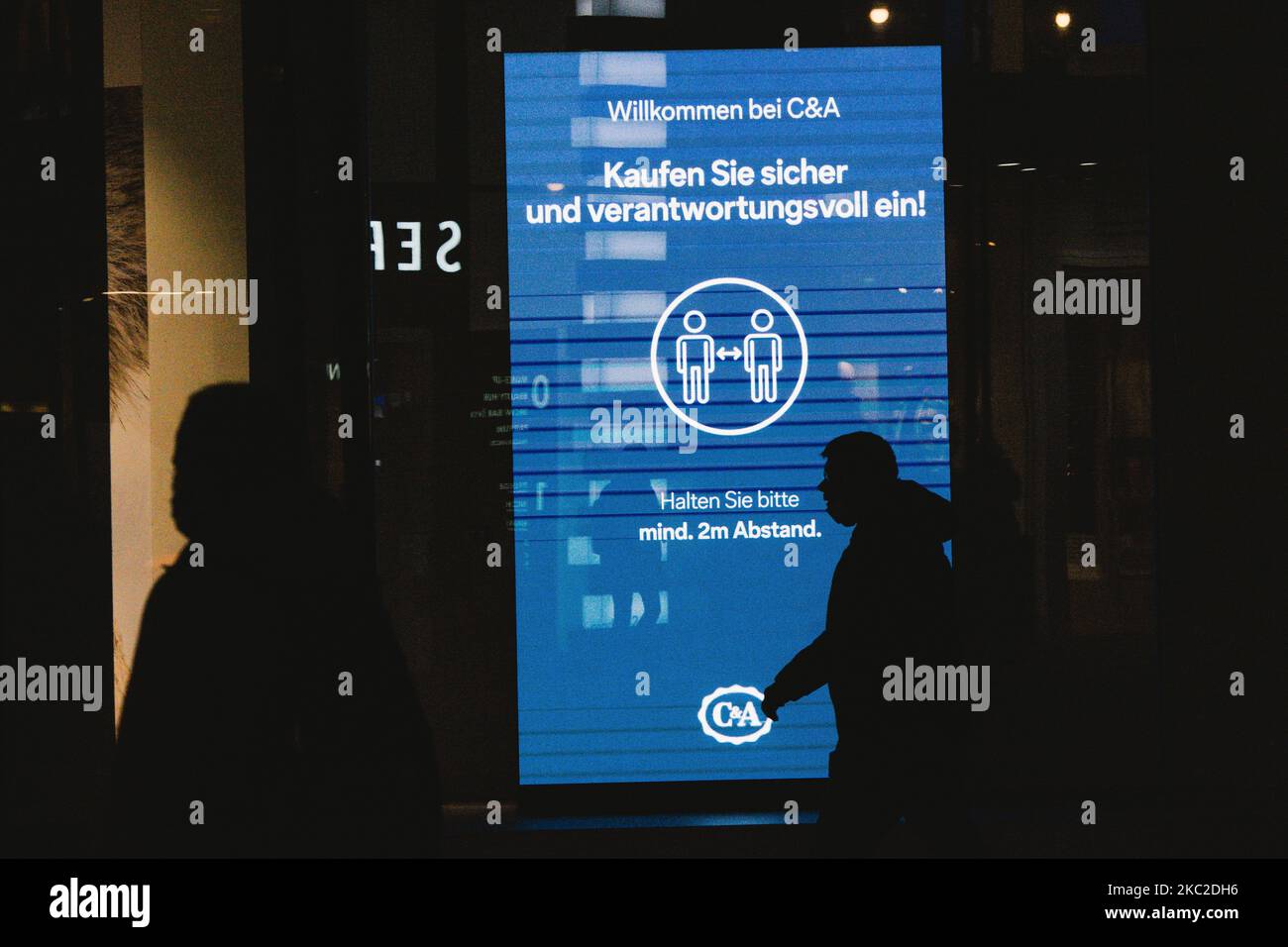 social distance awareness sign is seen in the city center of Cologne ...