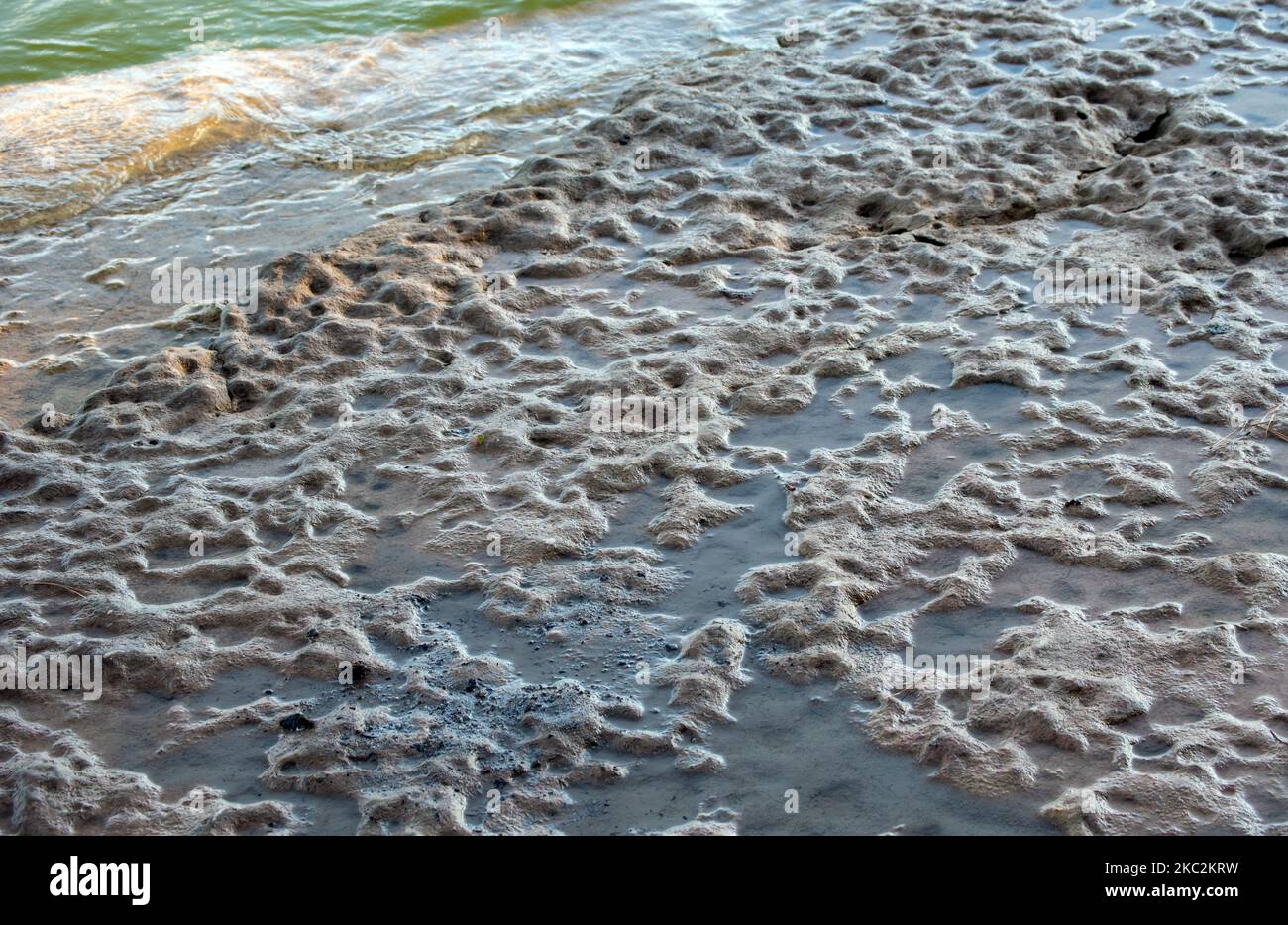 Water rushing in and out over the hard stone floor has created a mass ...