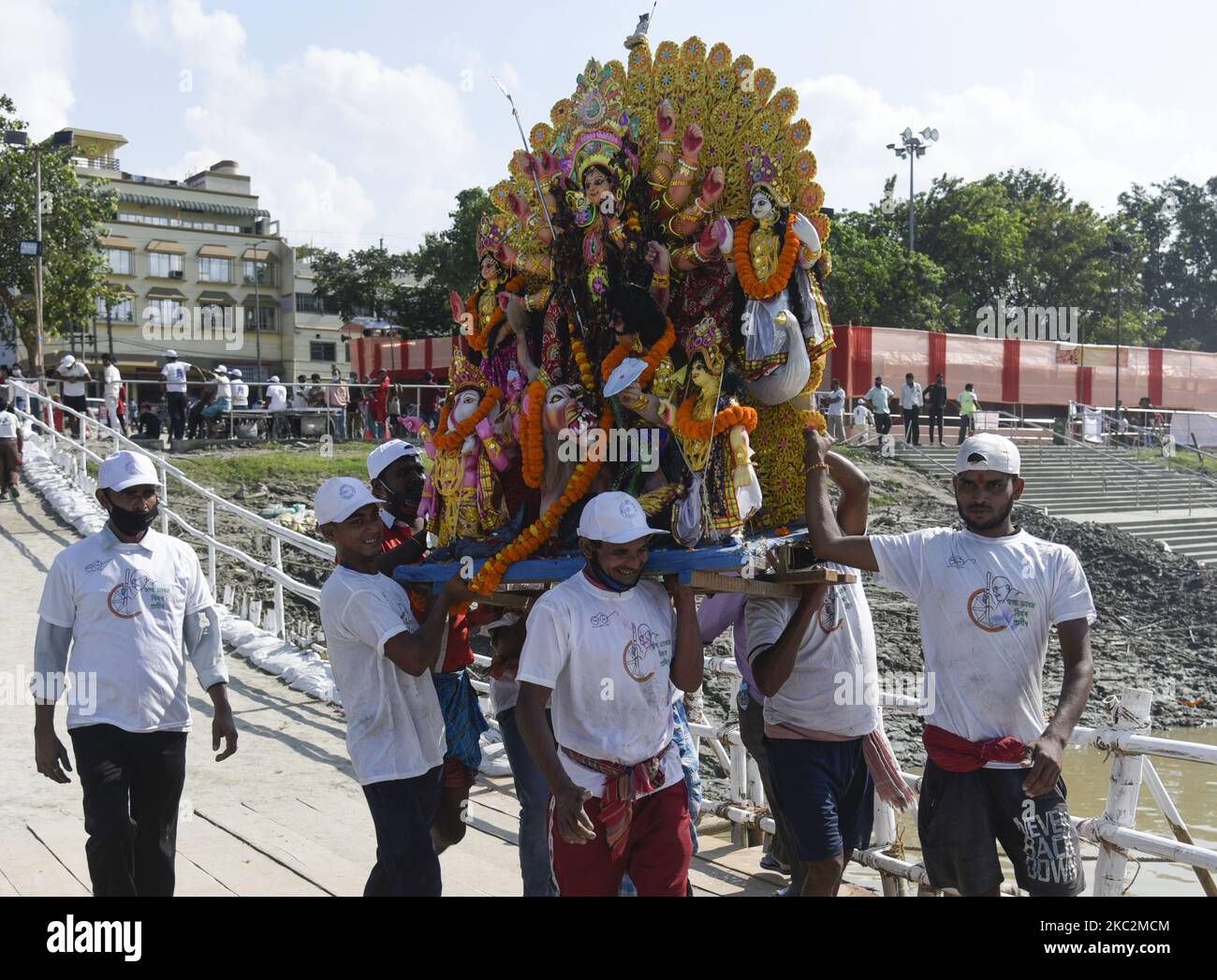 Municipal workers carry an idol of Hindu Goddess Durga for immersion in ...