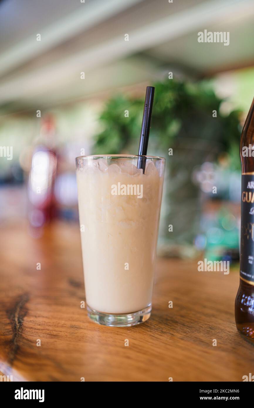 The vertical view of a glass of white cold drink over a wooden surface ...