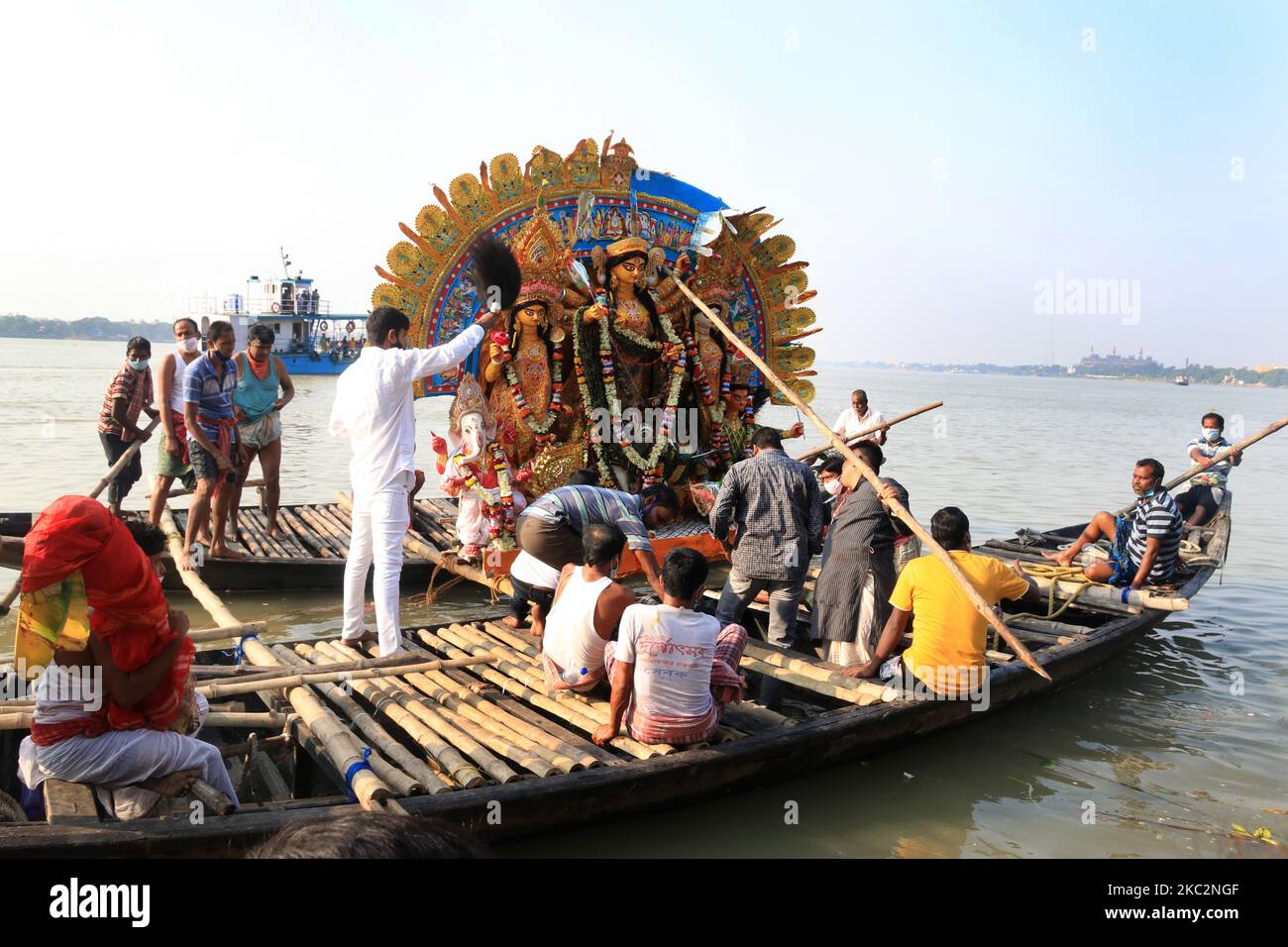 Devotees and labourers load an idol of a statue of the ten-handed Hindu ...