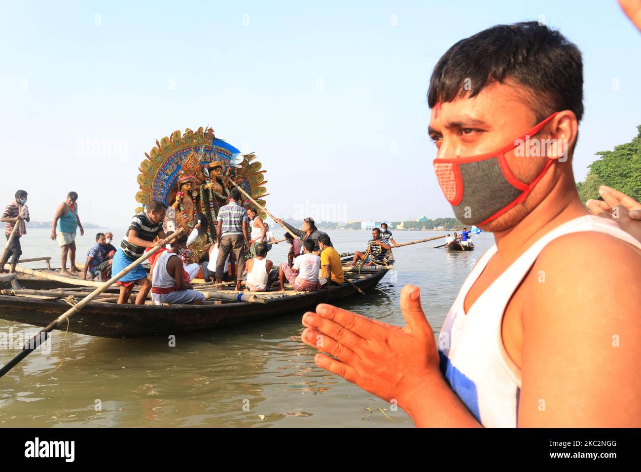 Devotees and labourers load an idol of a statue of the ten-handed Hindu ...