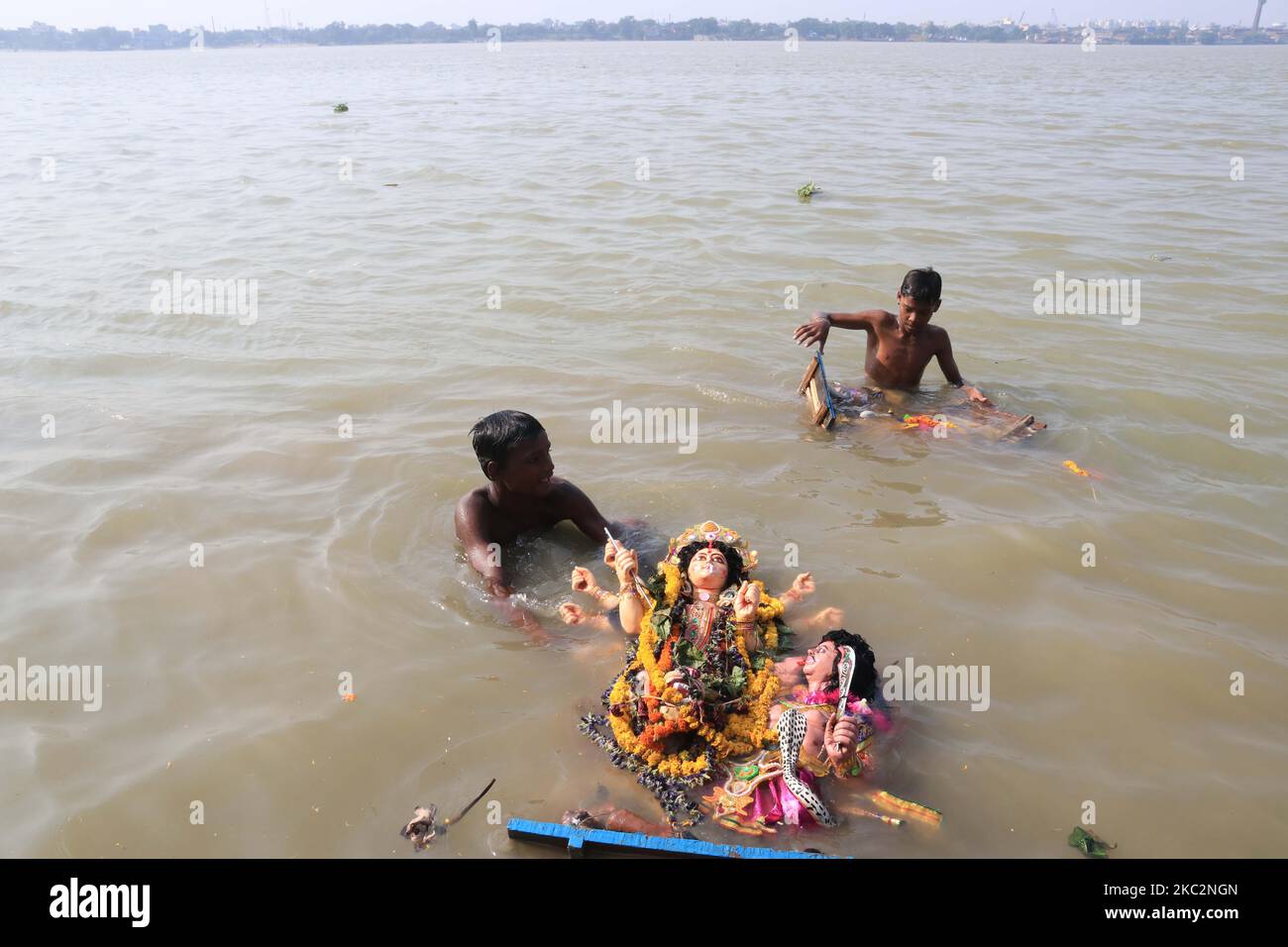 An idol of a statue of the ten-handed Hindu Goddess Durga floats in the ...