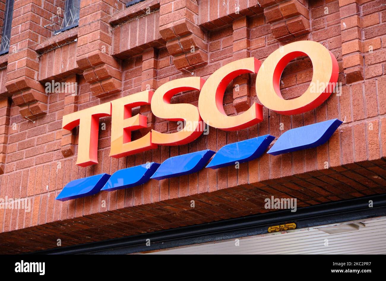 A closeup of the ''Tesco'' supermarket logo isolated on a brick wall ...