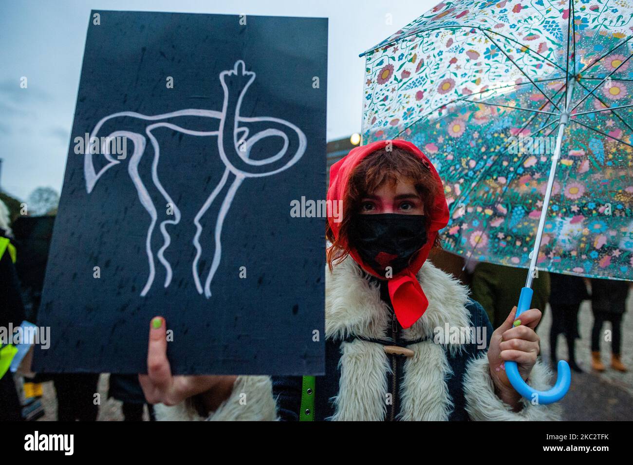A woman is holding a placard with an uterus drawn on it, in solidarity ...
