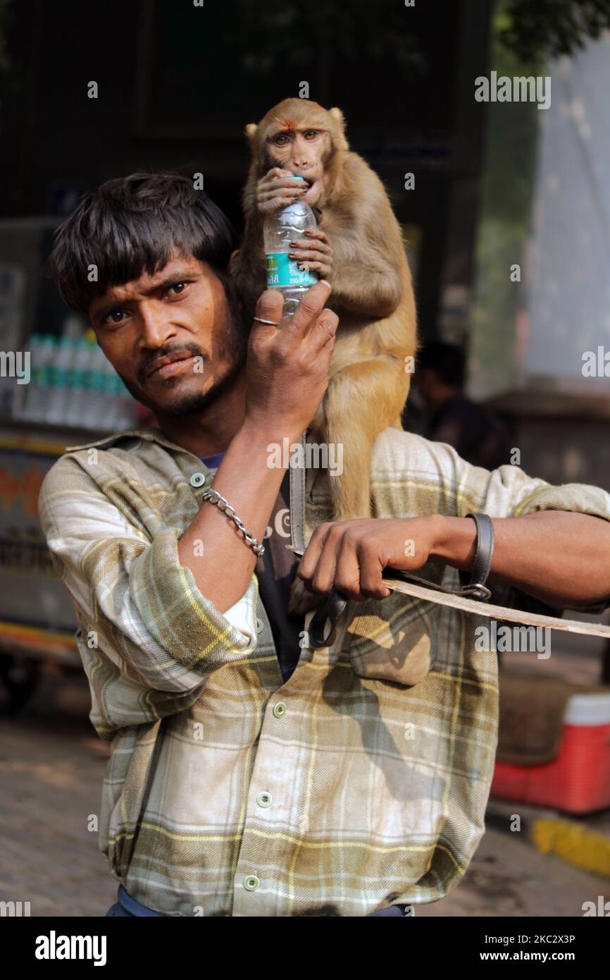 A man without mask poses for an image with his monkey at Connaught ...