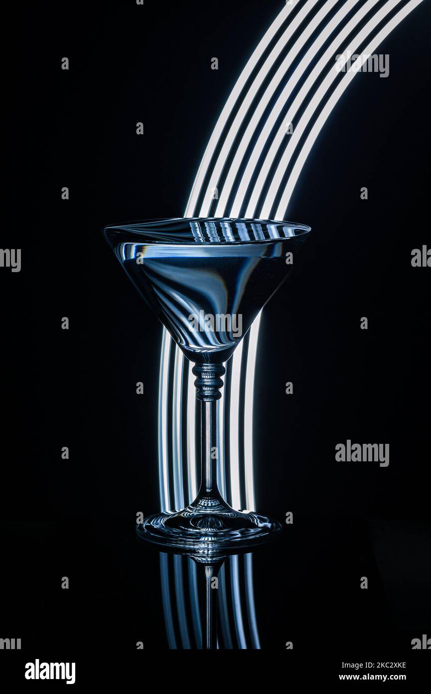 Cocktail glass on a black background with light painting streaks ...