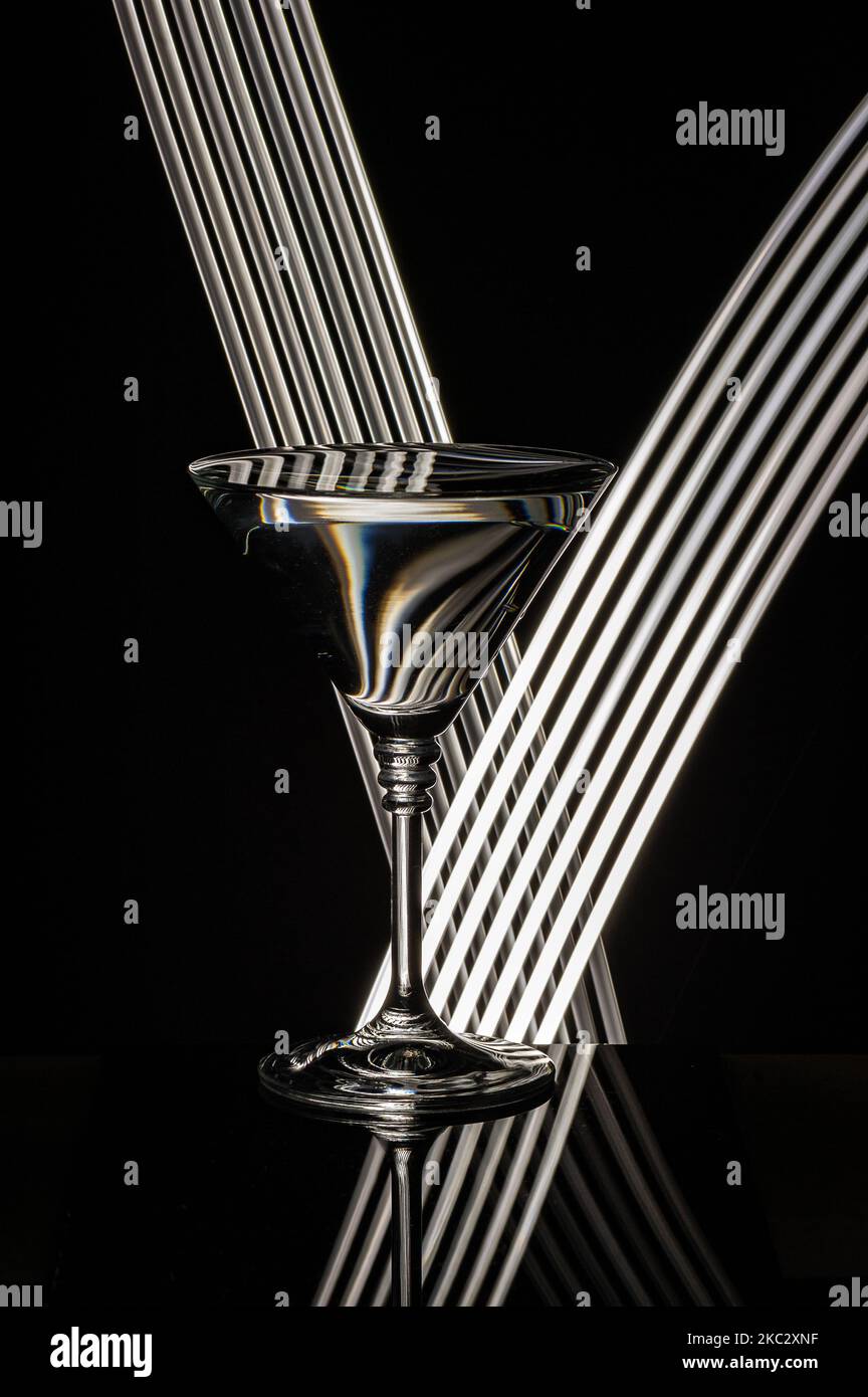 Cocktail glass on a black background with light painting streaks ...
