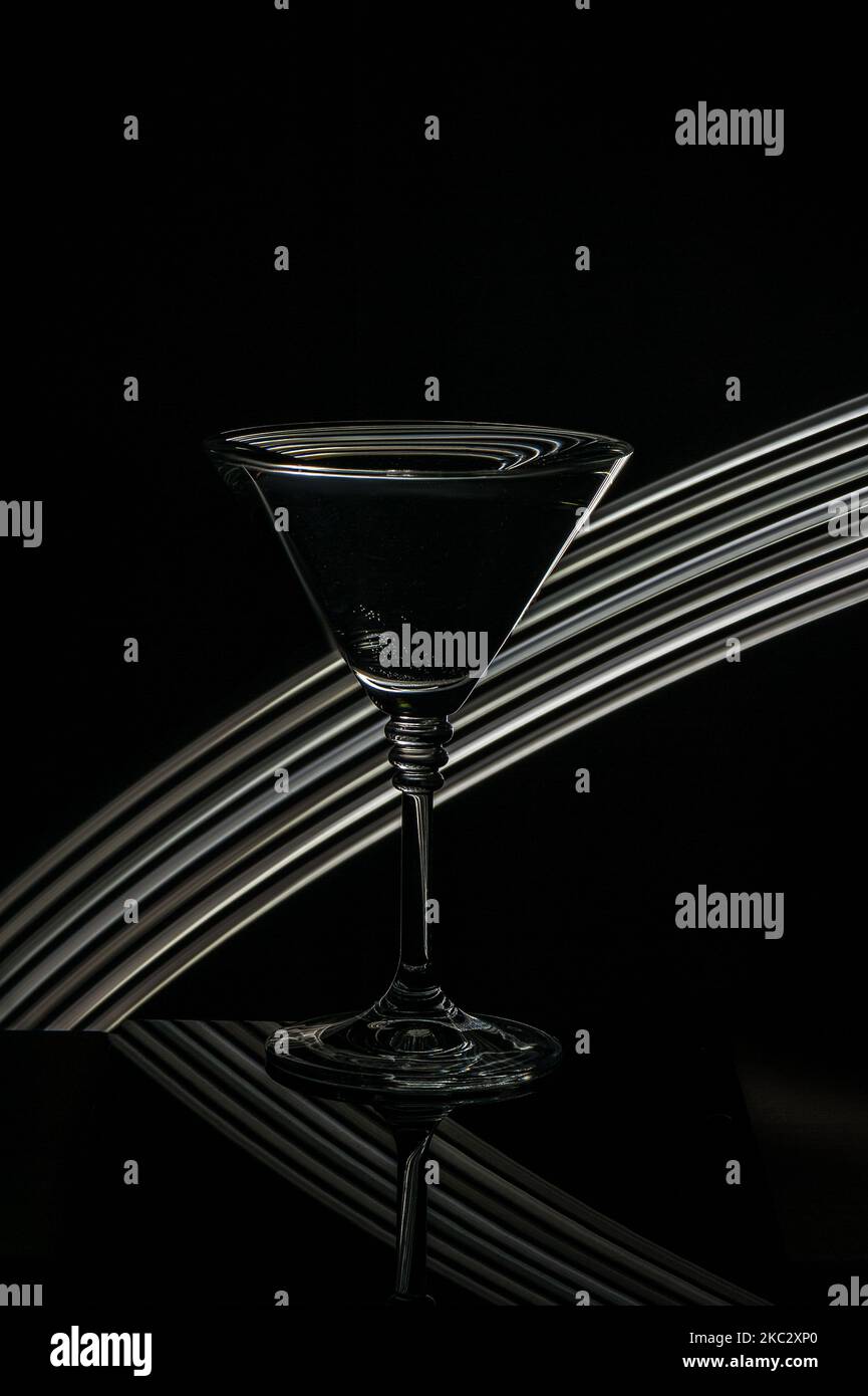 Cocktail glass on a black background with light painting streaks ...