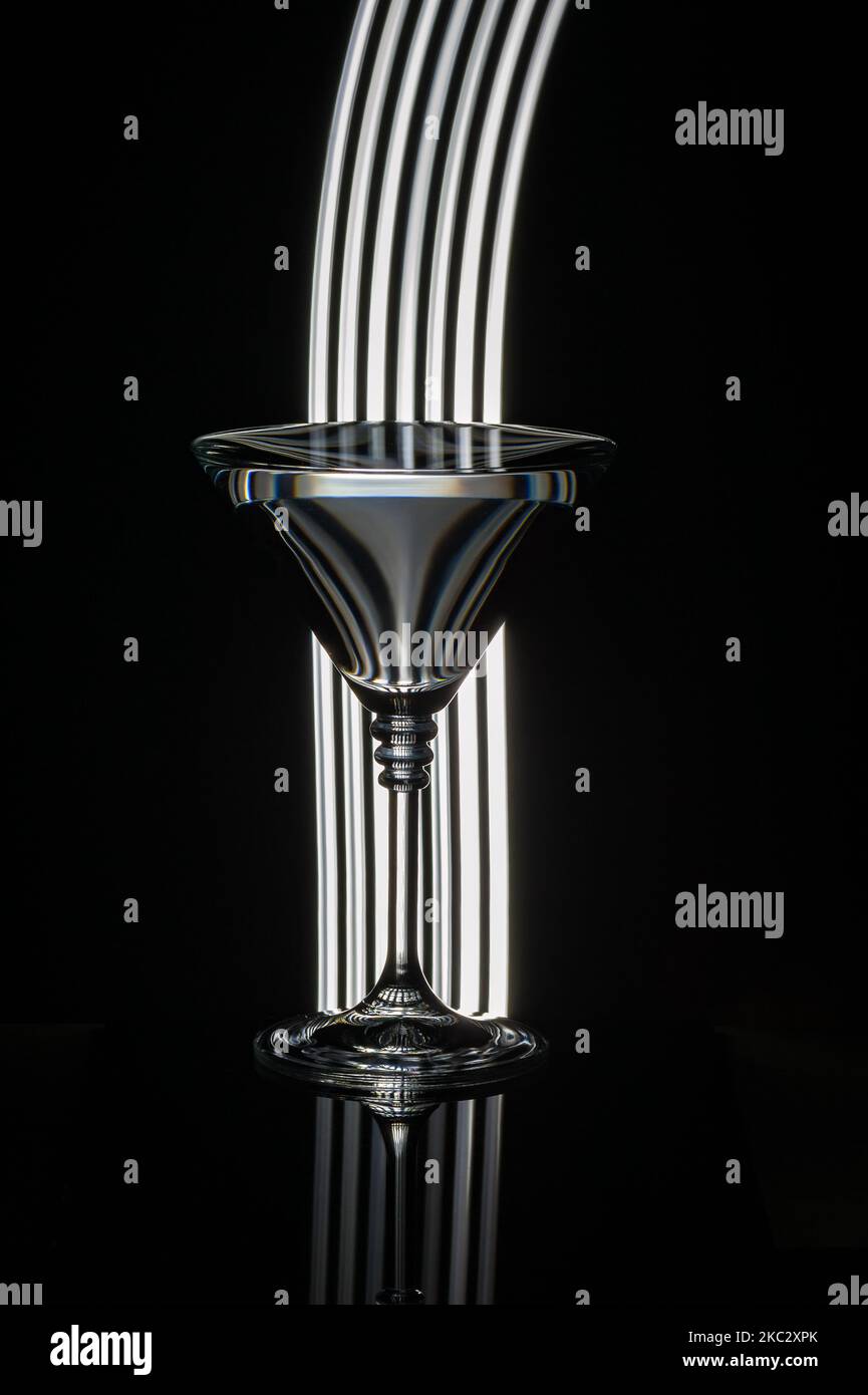 Cocktail glass on a black background with light painting streaks ...