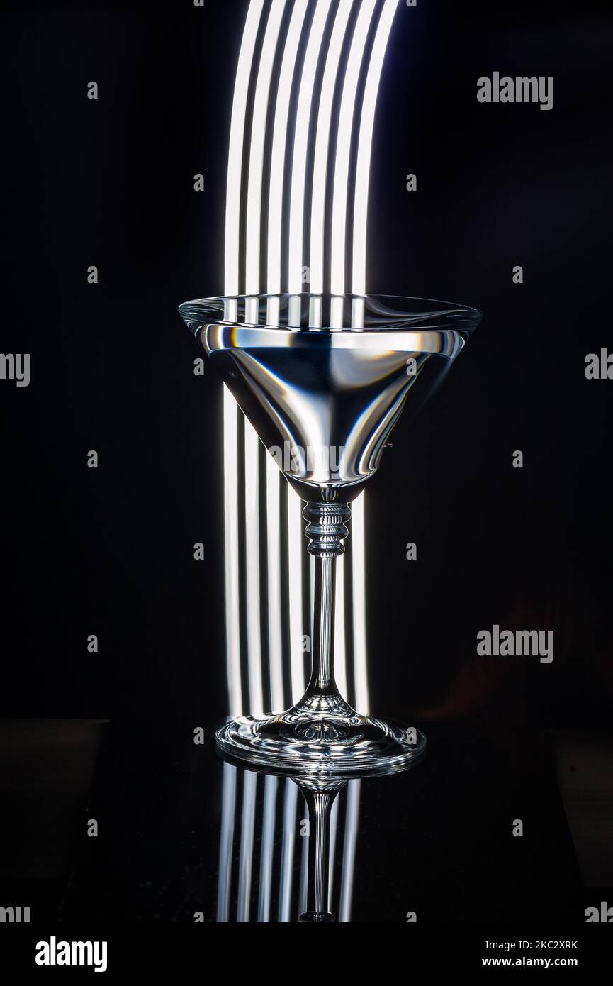 Cocktail glass on a black background with light painting streaks ...