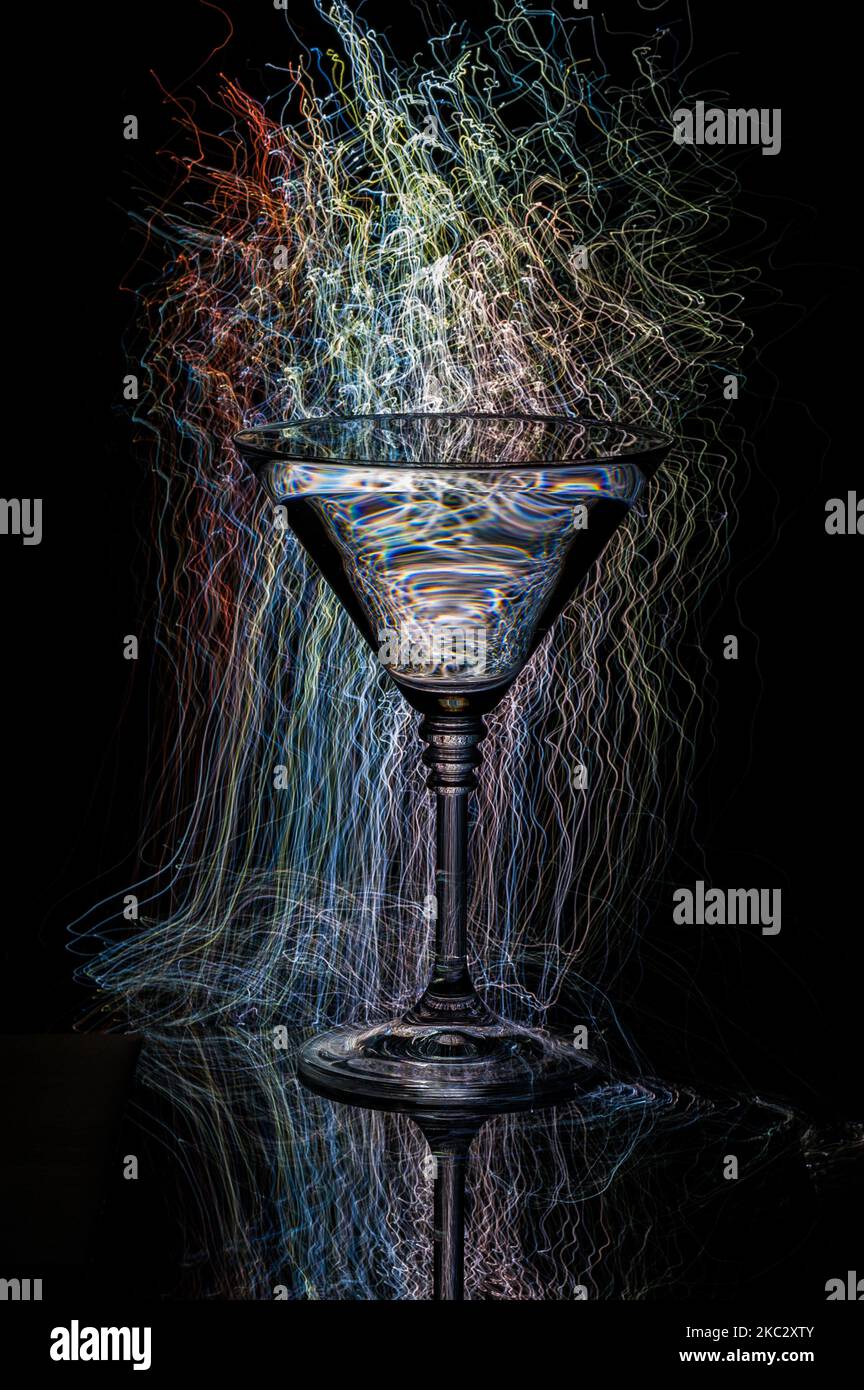 Cocktail glass on a black background with light painting streaks ...