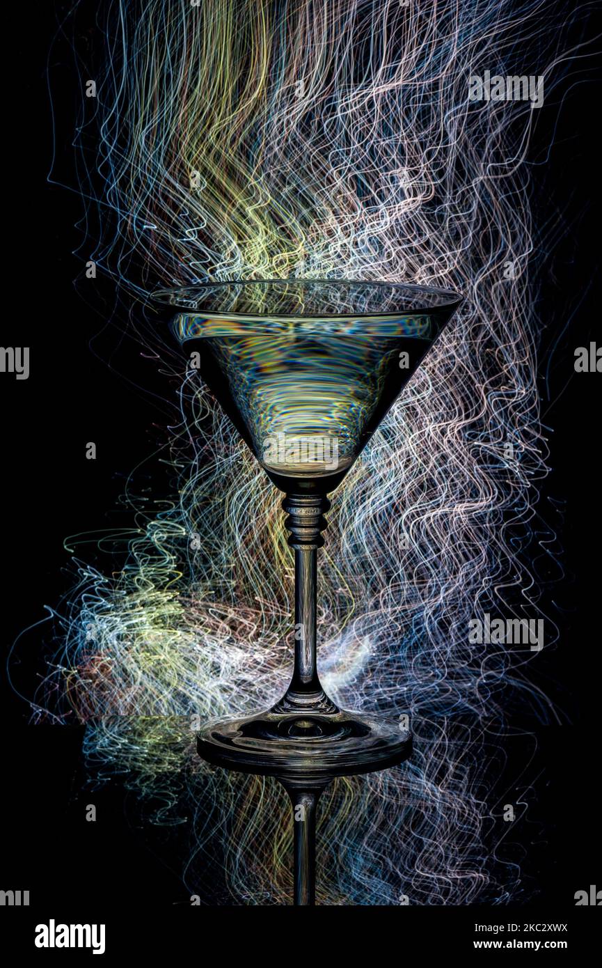 Cocktail glass on a black background with light painting streaks ...
