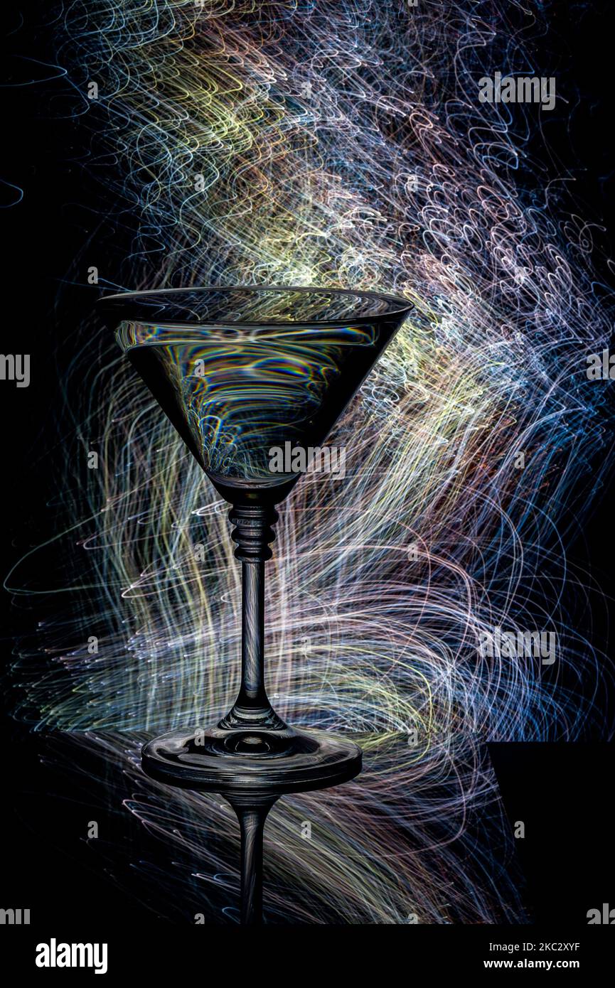 Cocktail glass on a black background with light painting streaks ...