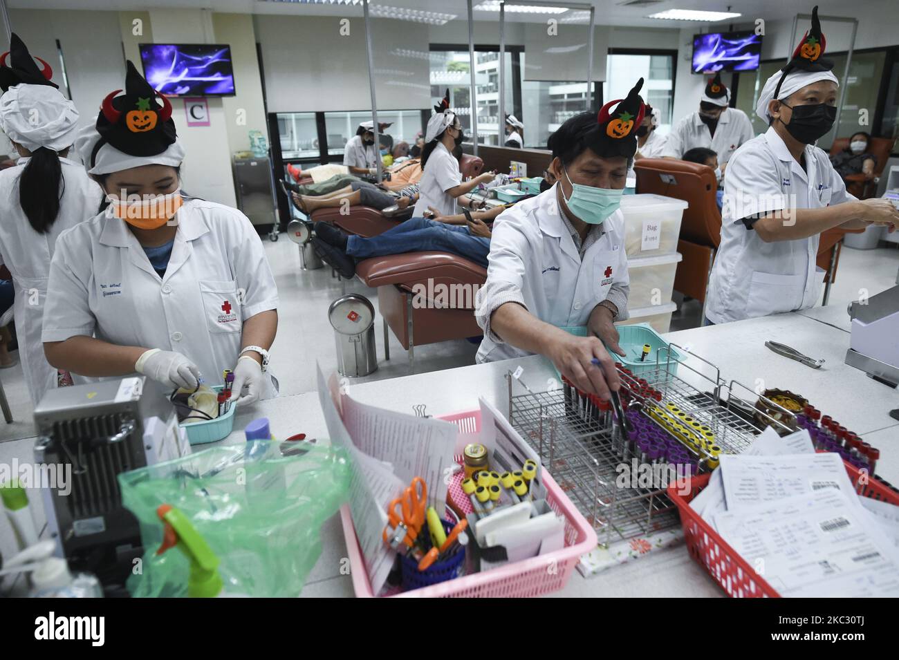 A staff members wearing devil horn decorations during a Halloween blood ...