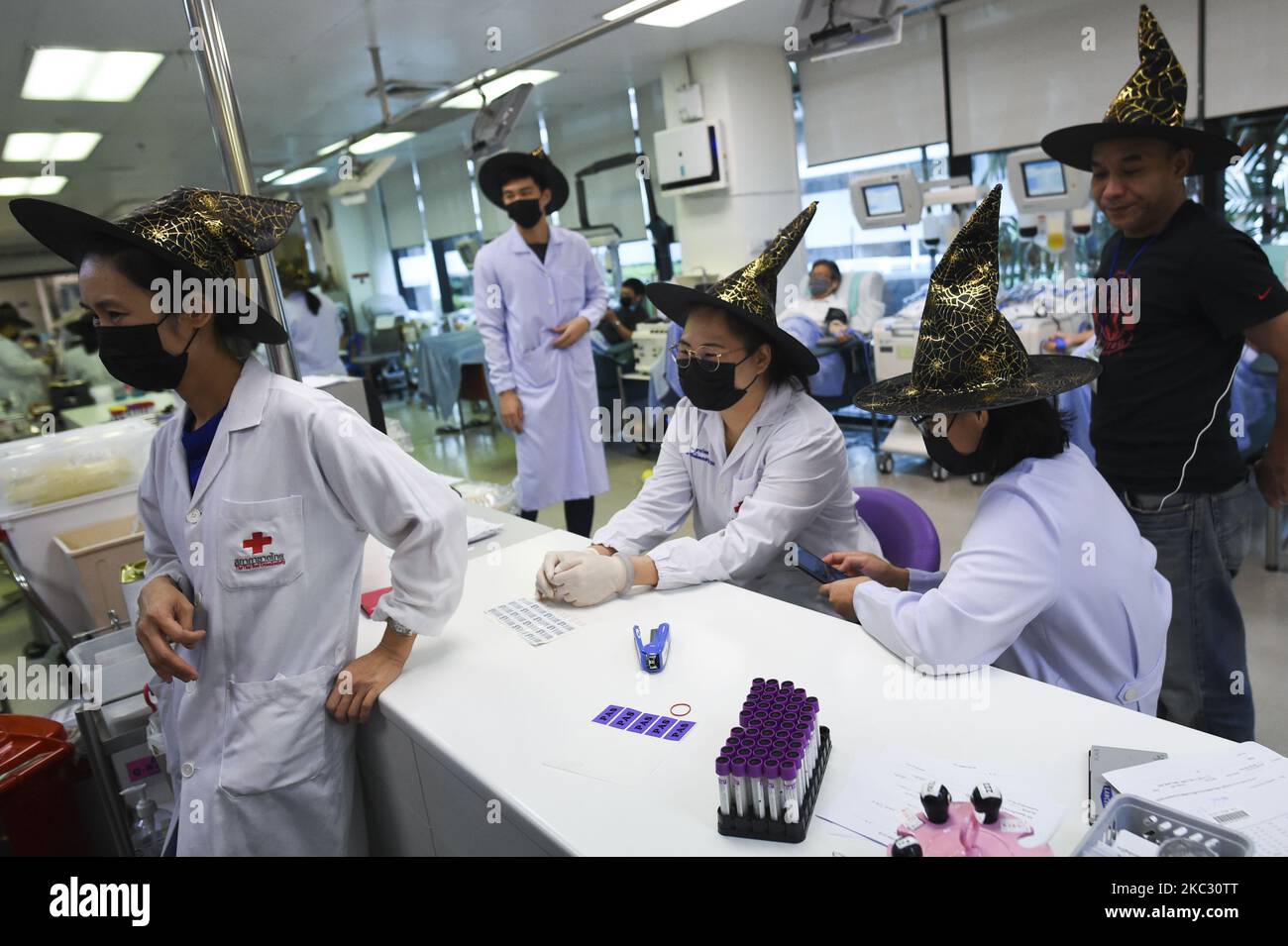 A staff members wearing devil horn decorations during a Halloween blood ...