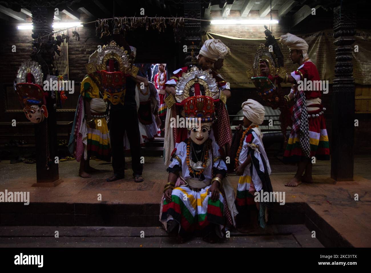 A man attired as deity adjusts the mask before performing traditional ...