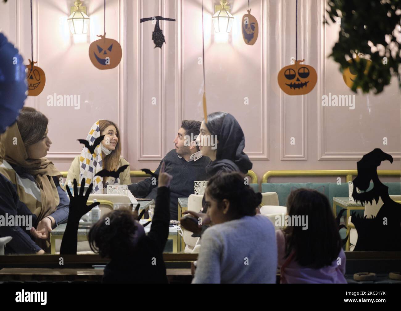 Iranian youth sit in a cafe that is decorated for Halloween ...