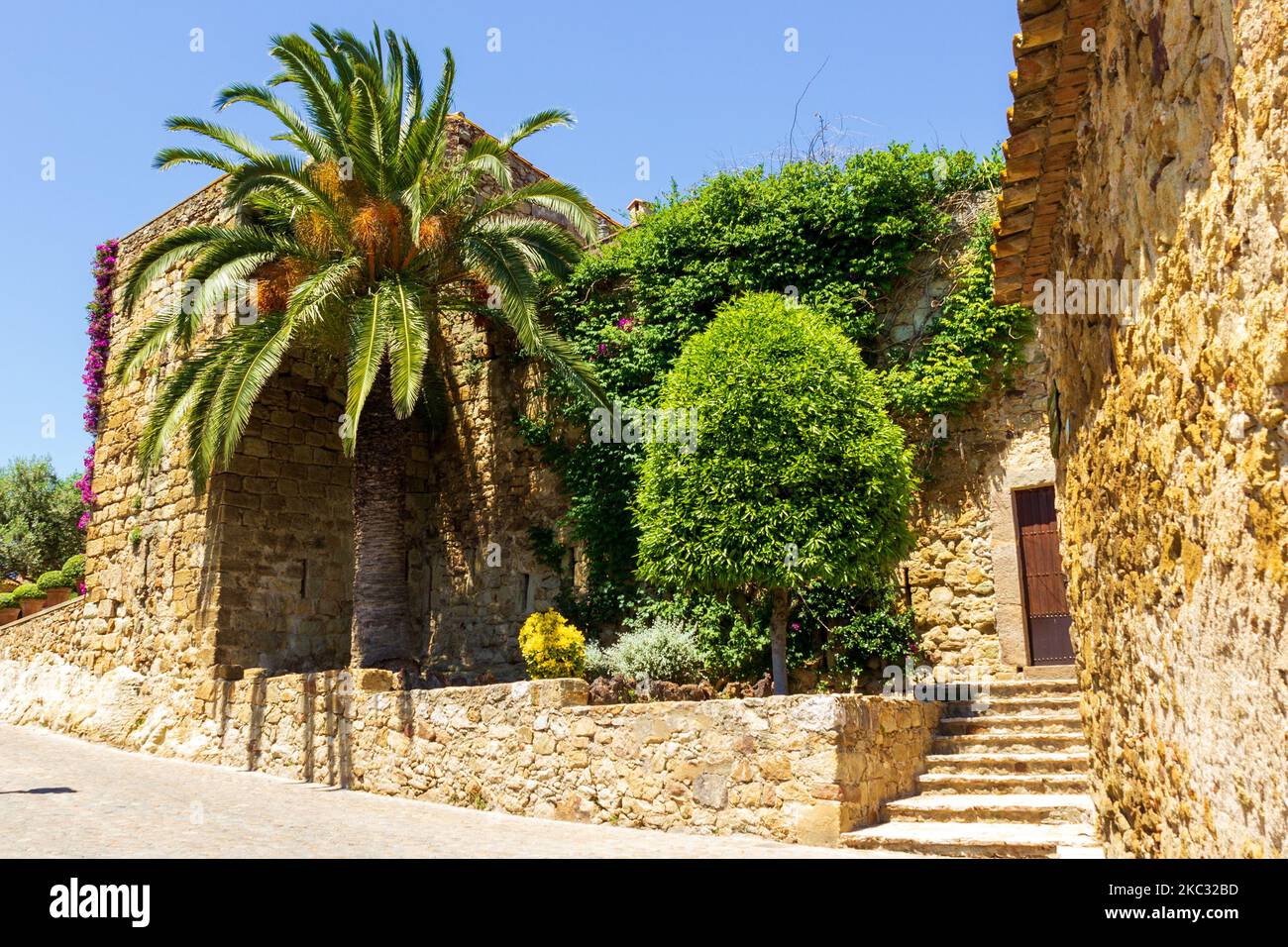 A stone building surrounded by bushes in fortified medieval town ...
