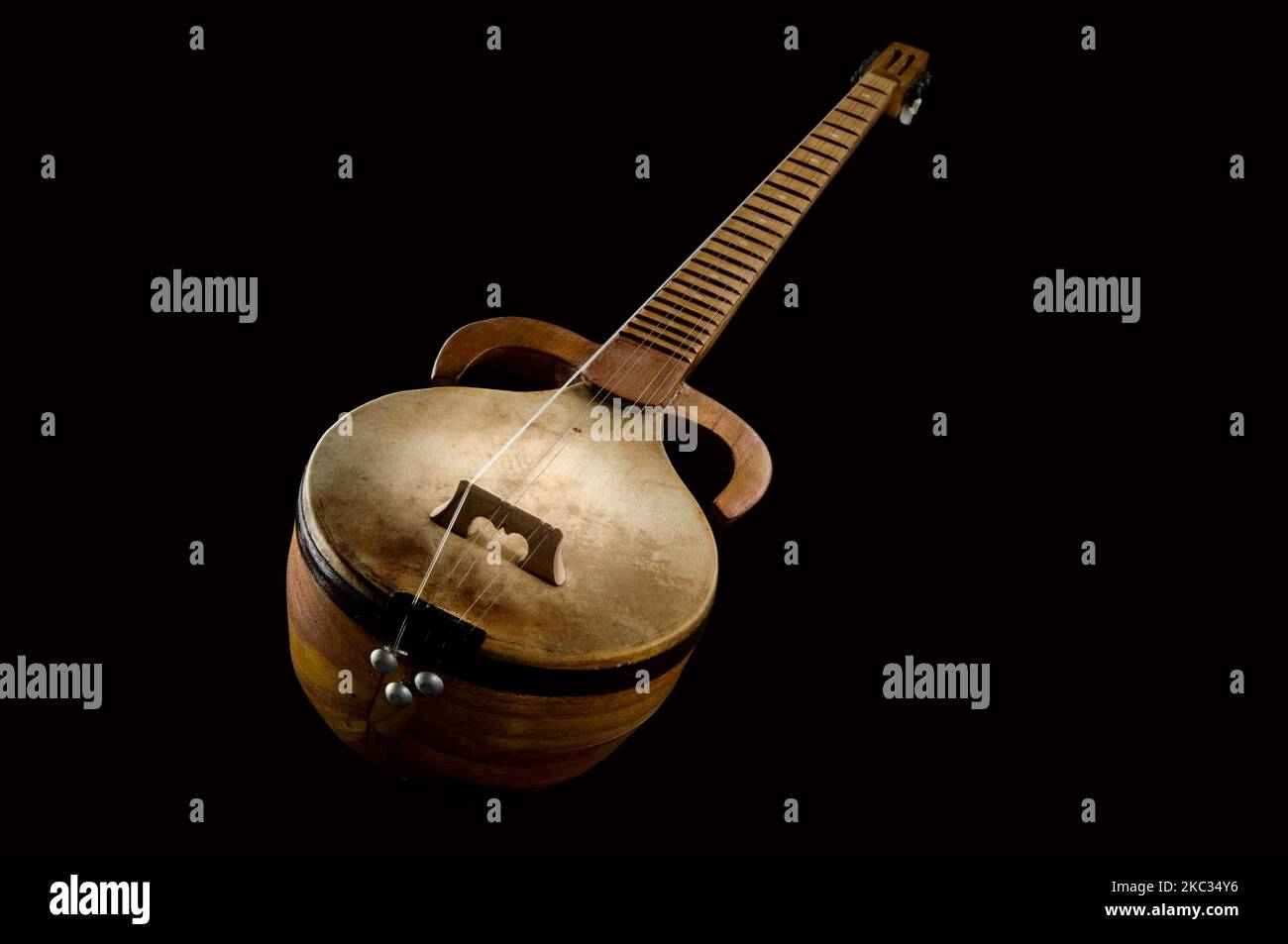 An ancient Asian stringed musical instrument on a black background ...