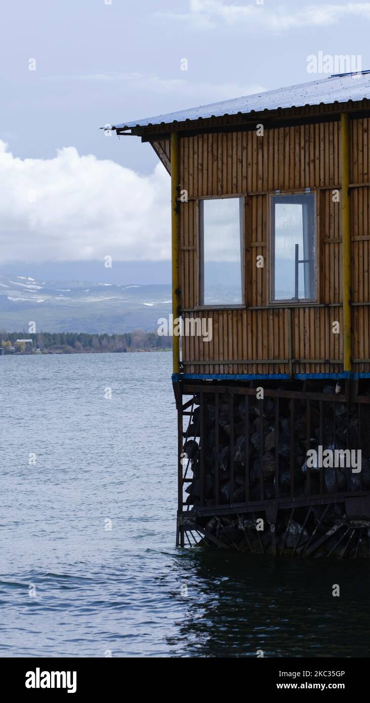 A vertical of a wooden stilt house over lake Sevan, Armenia Stock Photo ...
