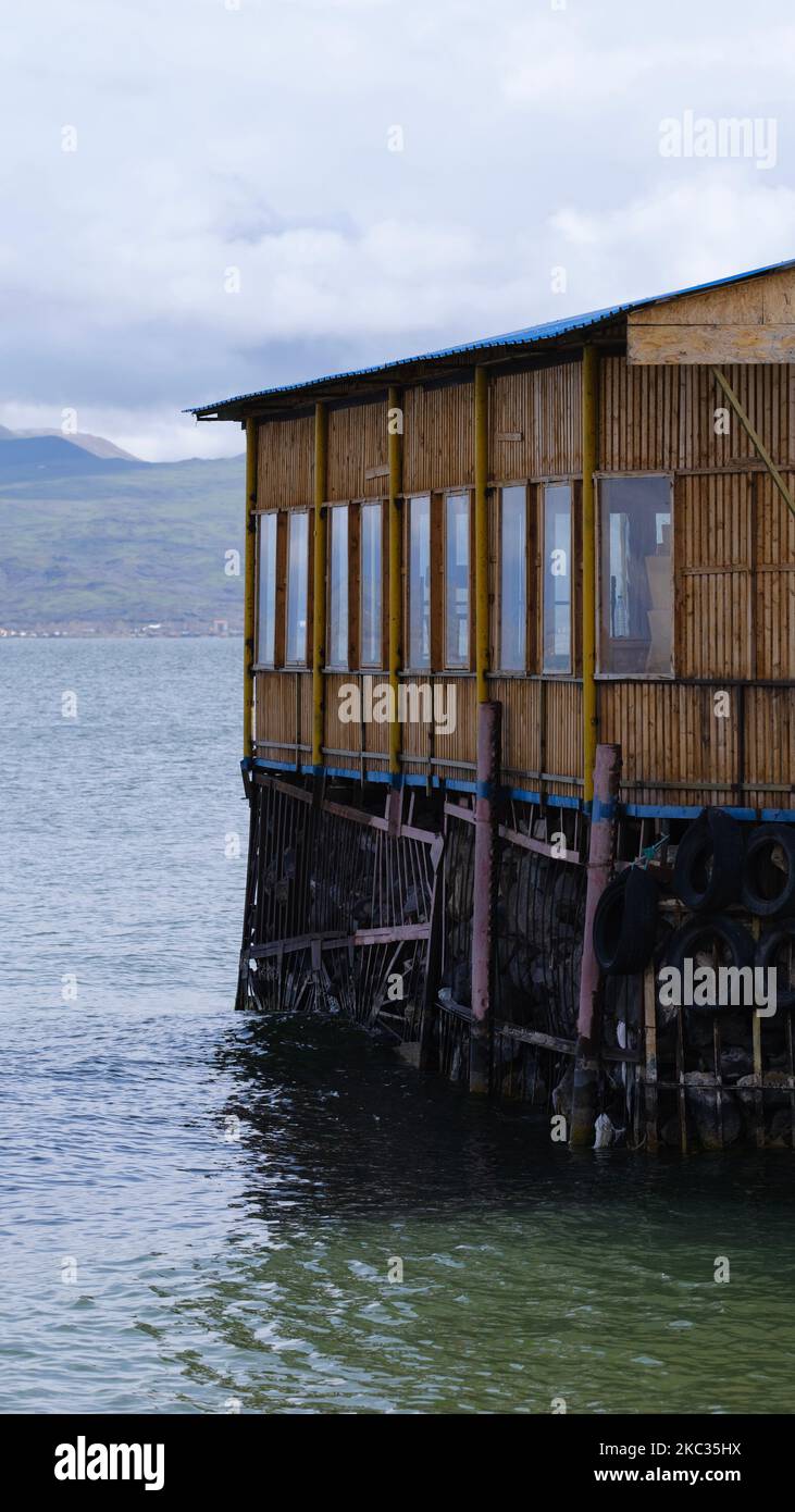 A vertical of a wooden stilt house over lake Sevan, Armenia Stock Photo ...