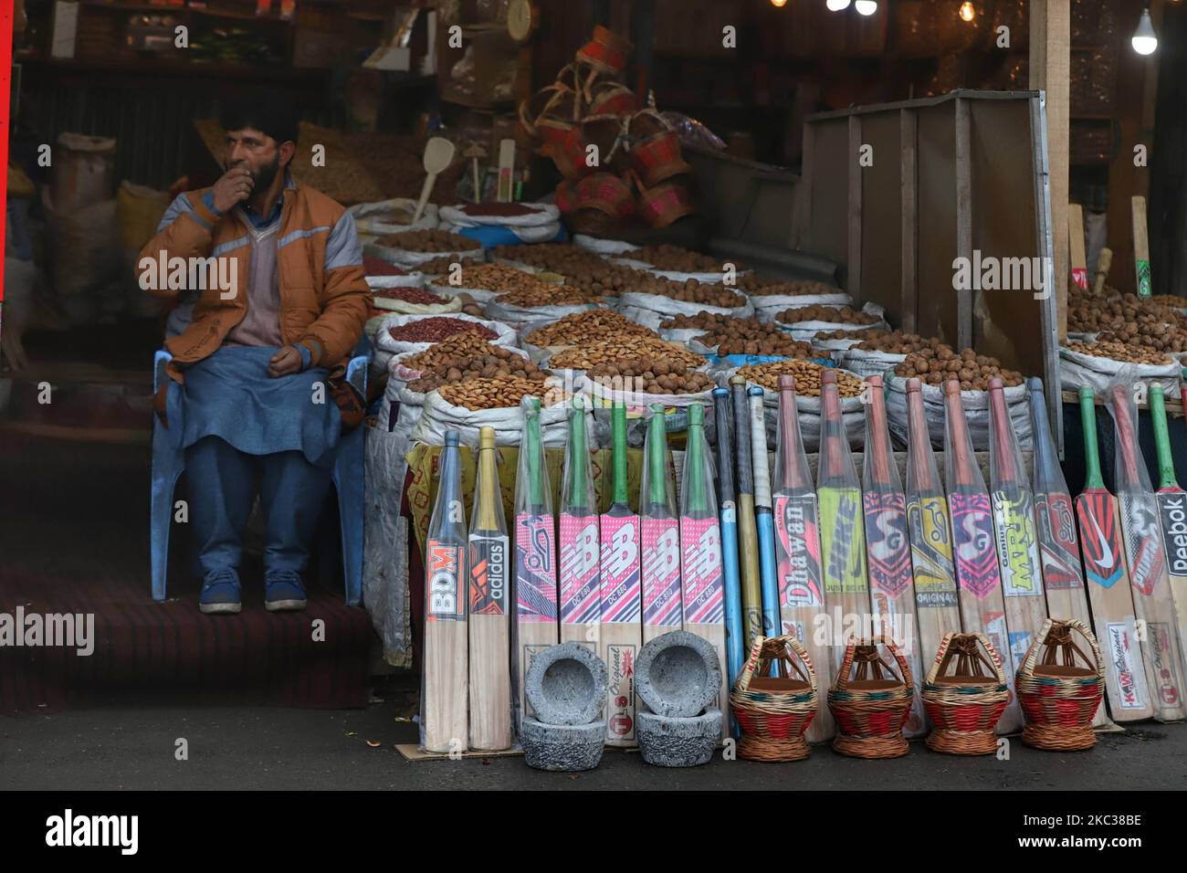 A man selling Dry Fruits and Cricket bats waits for the customers near ...