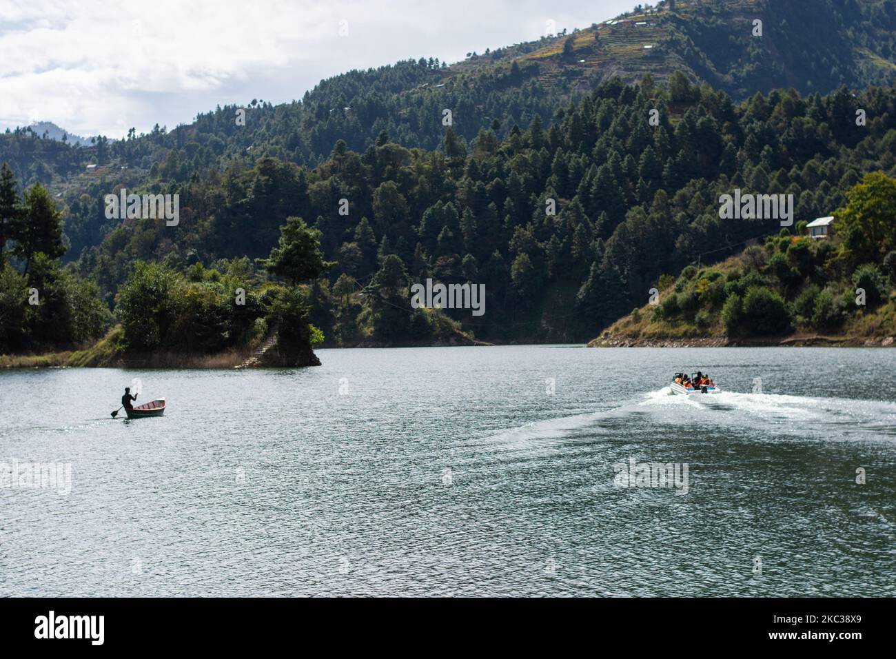 A man sails on a traditional boat while local tourists sail on a ...