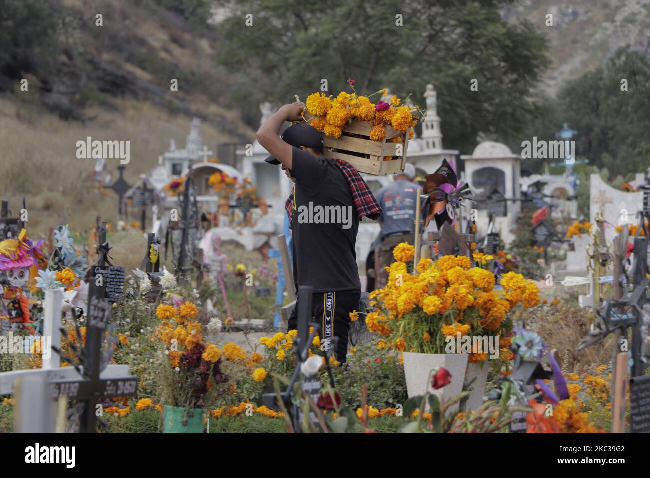 A person carries marigold flowers inside the Xico-Chalco Civil Pantheon ...