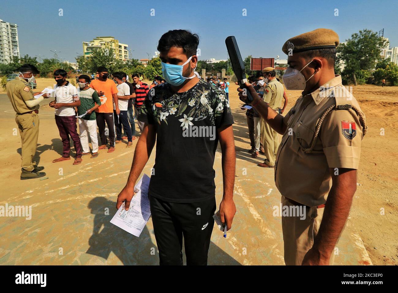 Candidates being screened as they arrive at an examination centre to ...