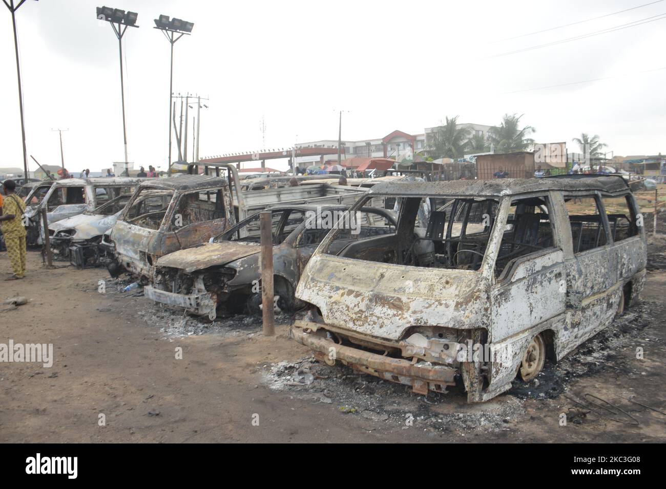 People stand next to burned cars after a tanker exploded on Lagos ...