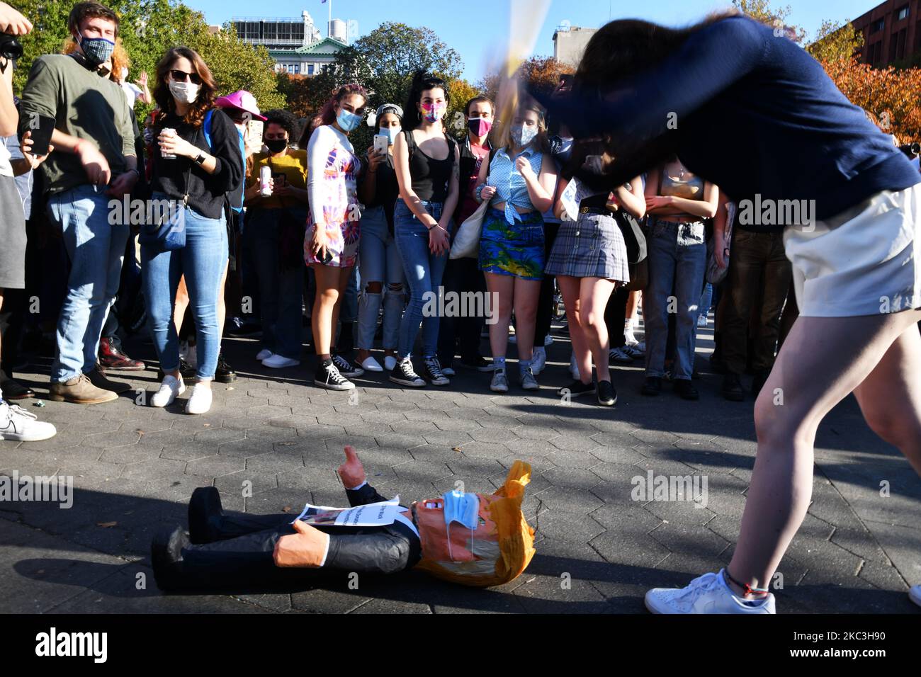 A woman beats an effigy of Donald Trump as New Yorkers celebrate in the ...