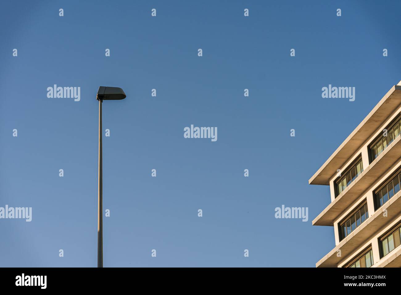 The low-angle view of a lamp column by a residential building under the ...