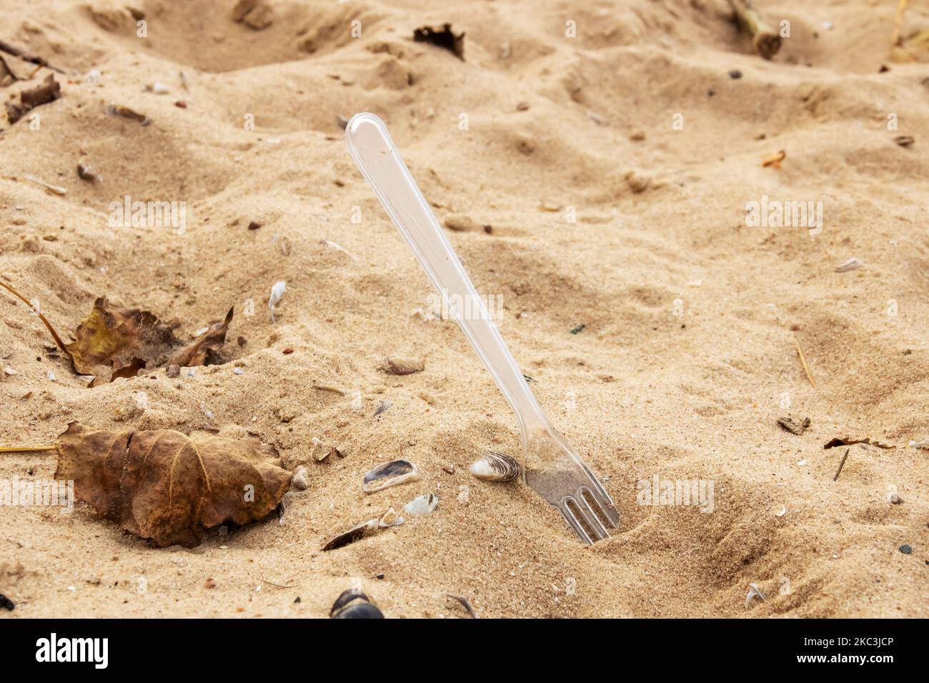 Plastic fork in the sand on the beach close up Stock Photo - Alamy