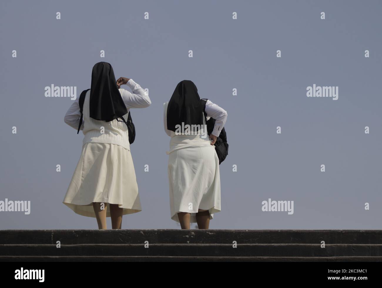 Two nuns climbing the steps of the esplanade of the Basilica of ...
